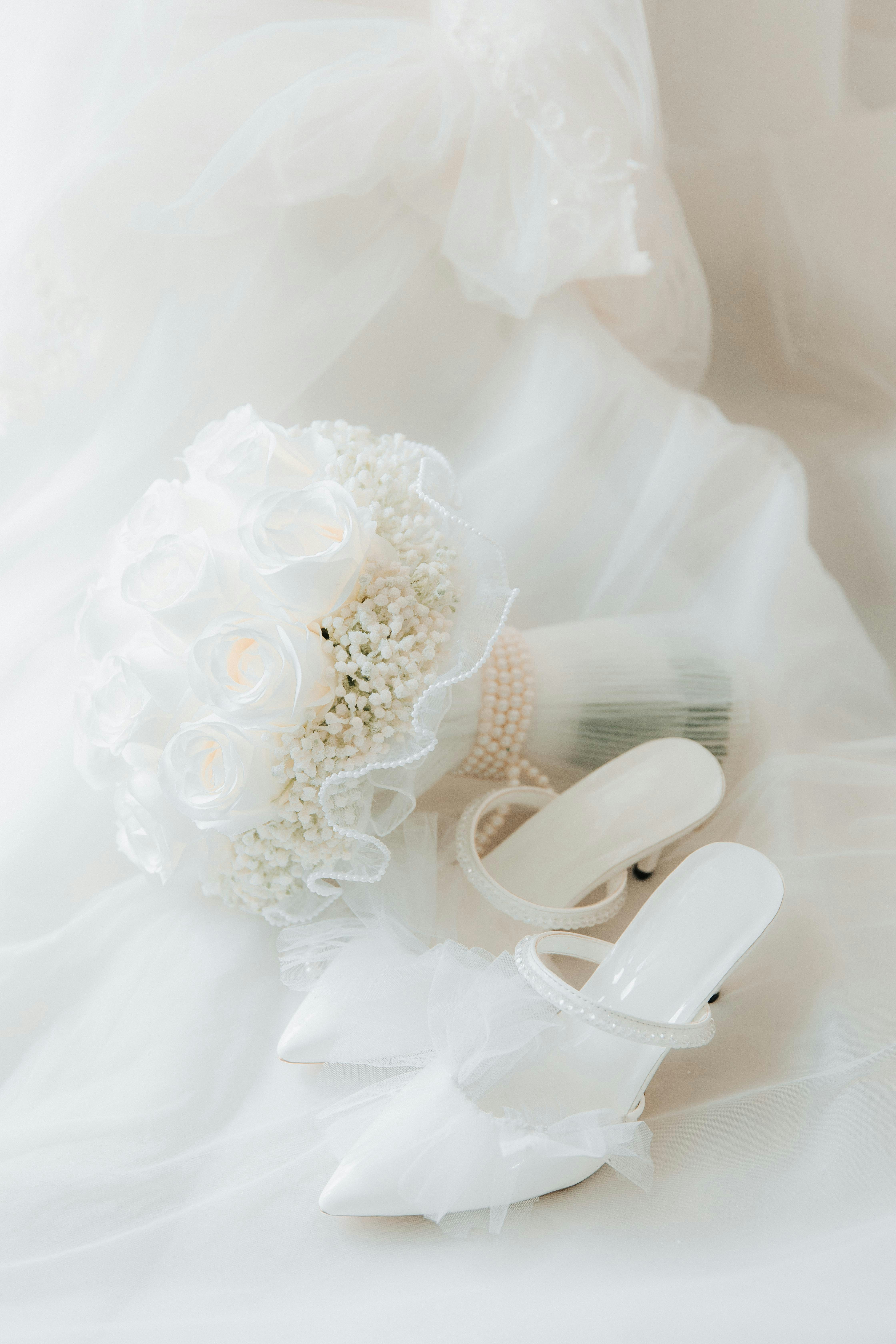Whispering White: bridal bouquet and satin heels resting on soft veil