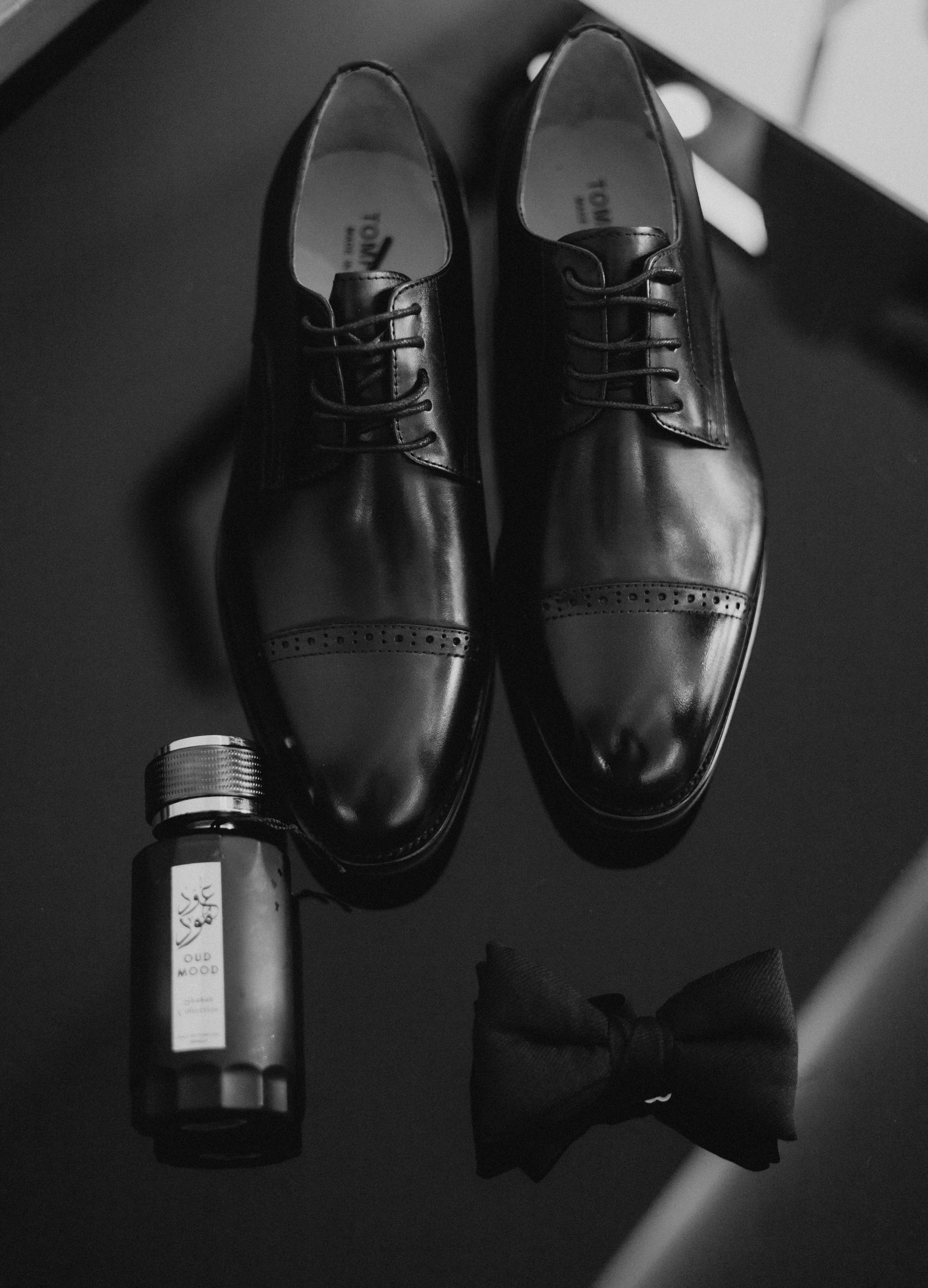 Polished Steps: Leather Shoes, Cologne, and Bow Tie in Monochrome