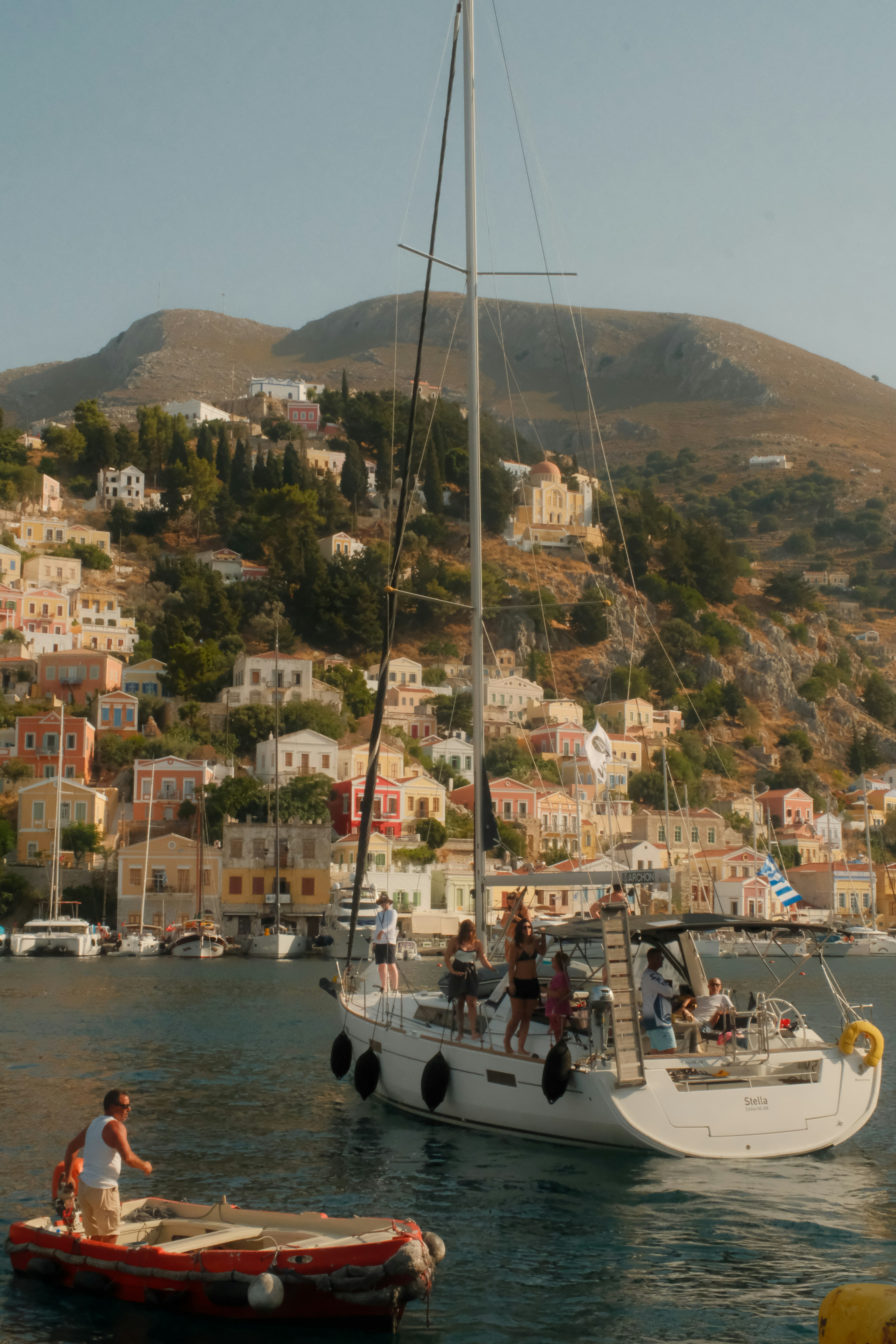 Harbor Sails and hillside village under a summer sky