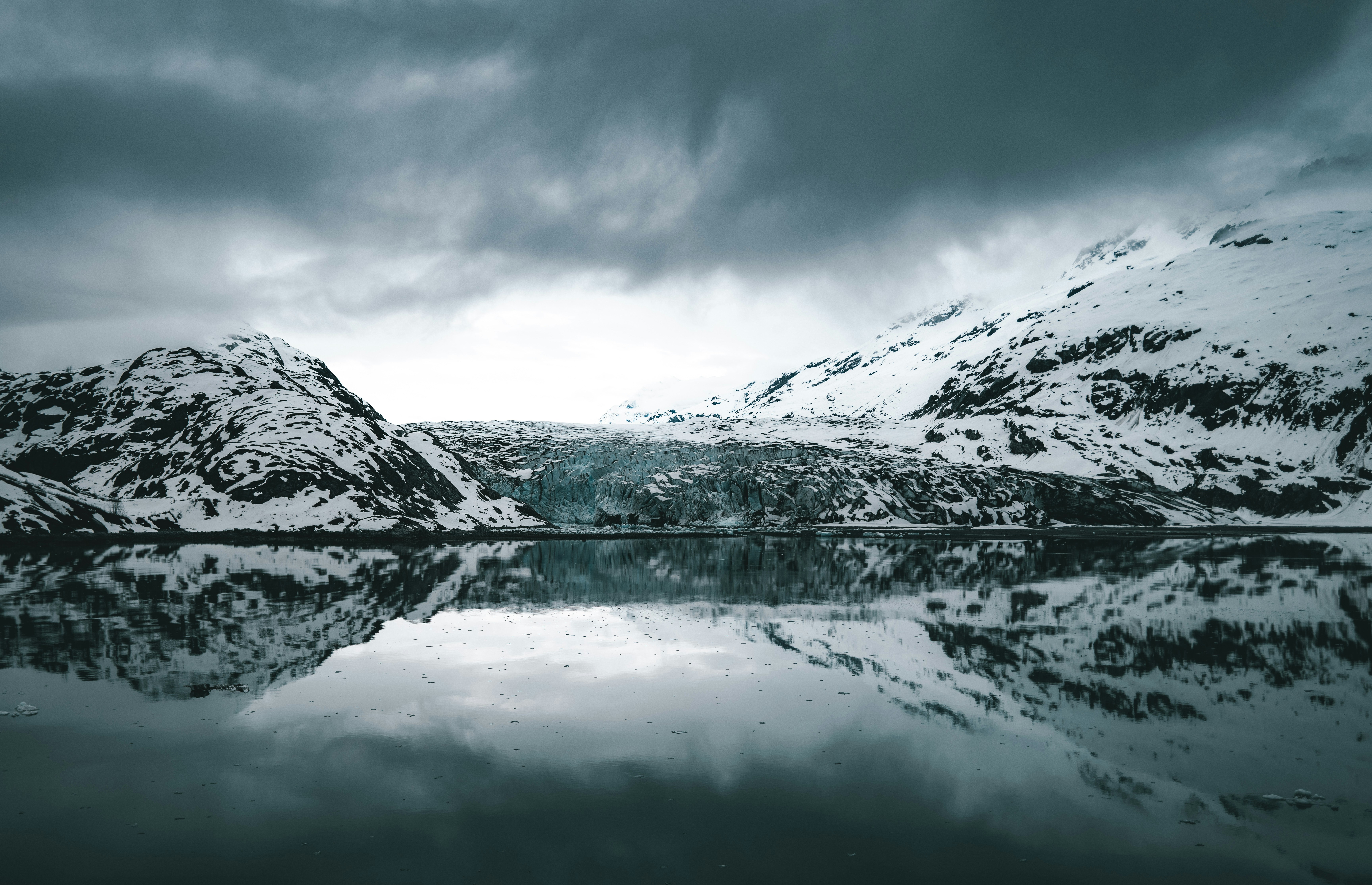 Symmetric Snowbound Ridge Across a Glassy Fjord