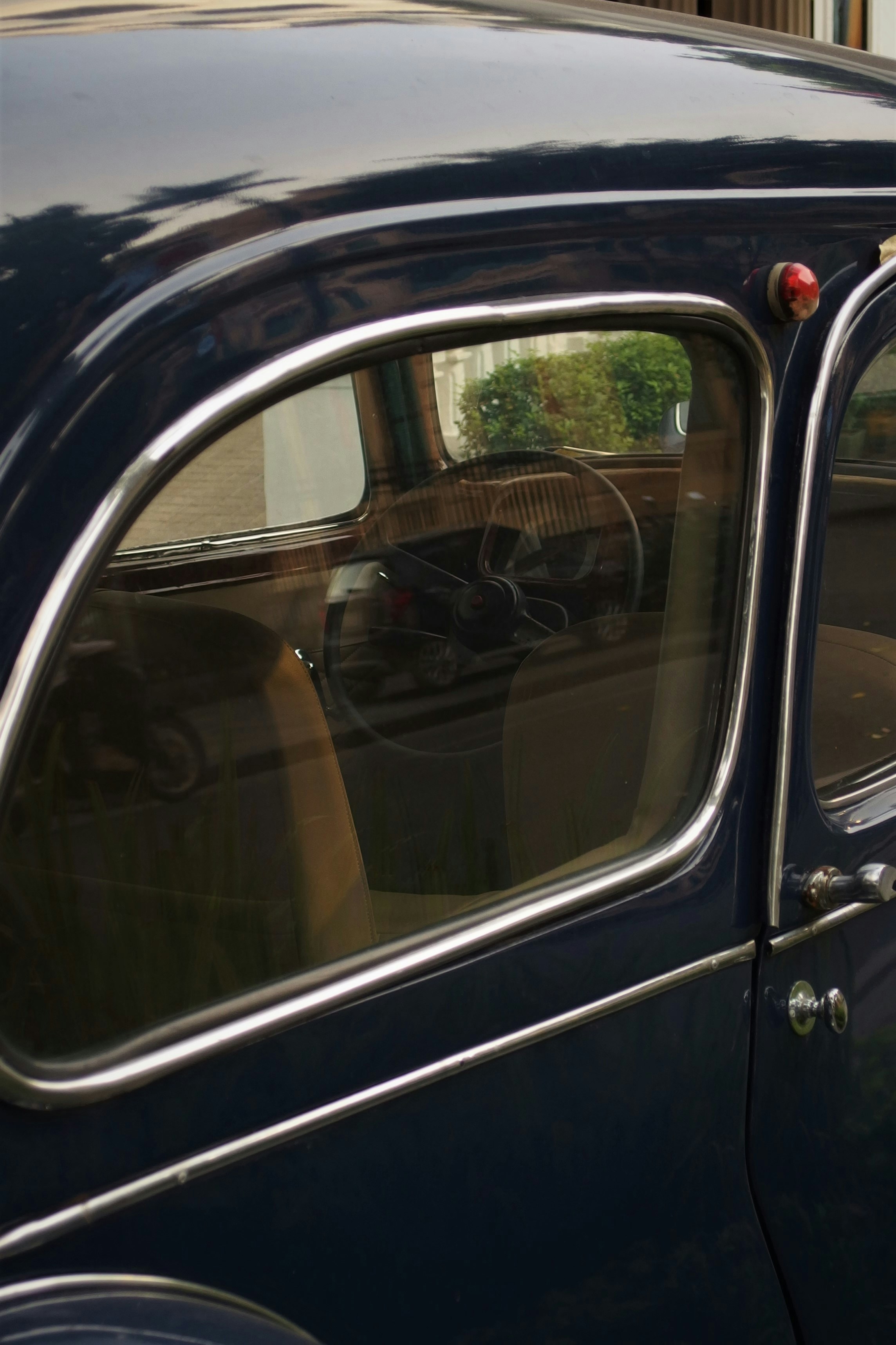 Reflection in the Driver’s Window: A Vintage Car’s Quiet Moment