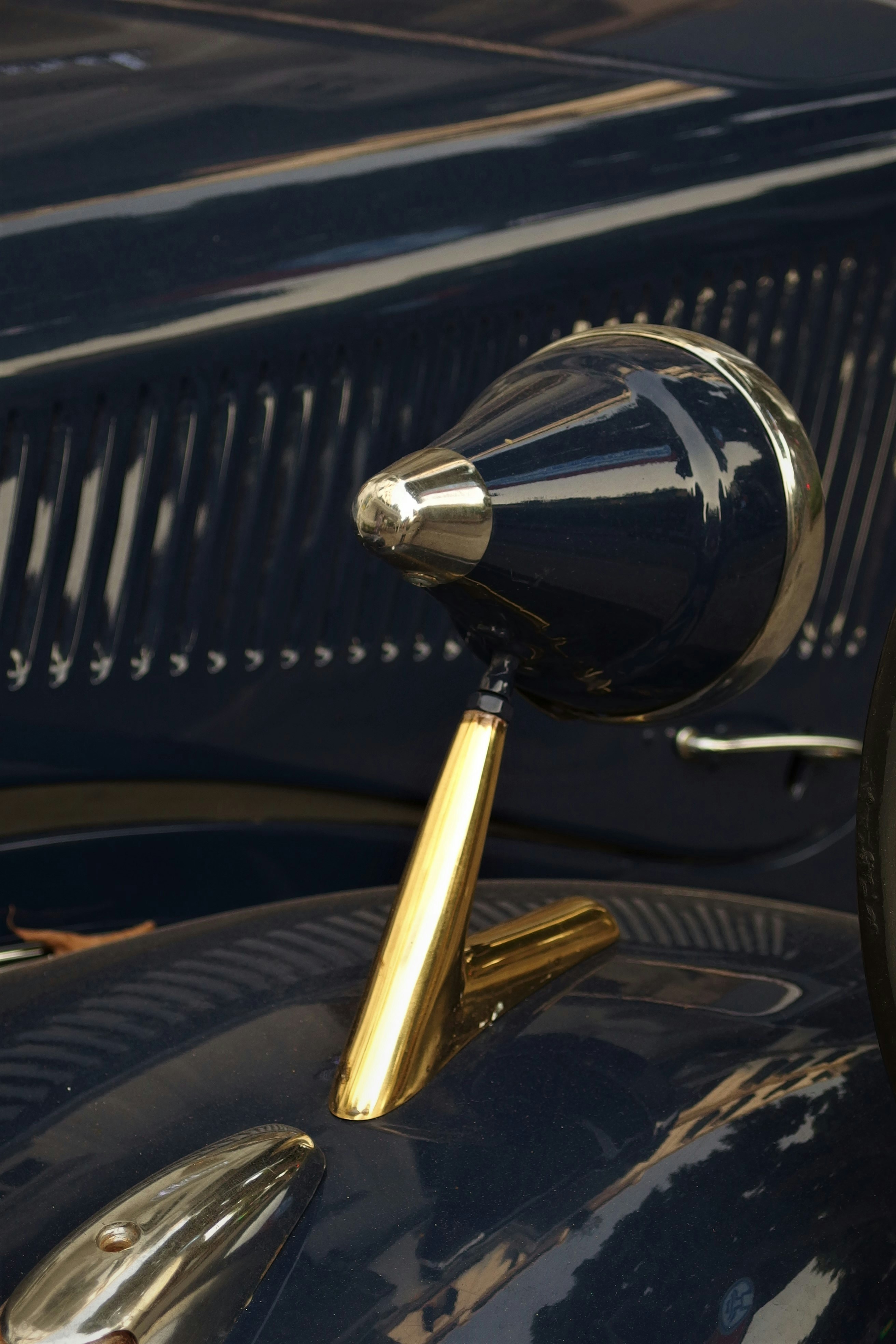 Glossy vintage car side mirror and hood ornament