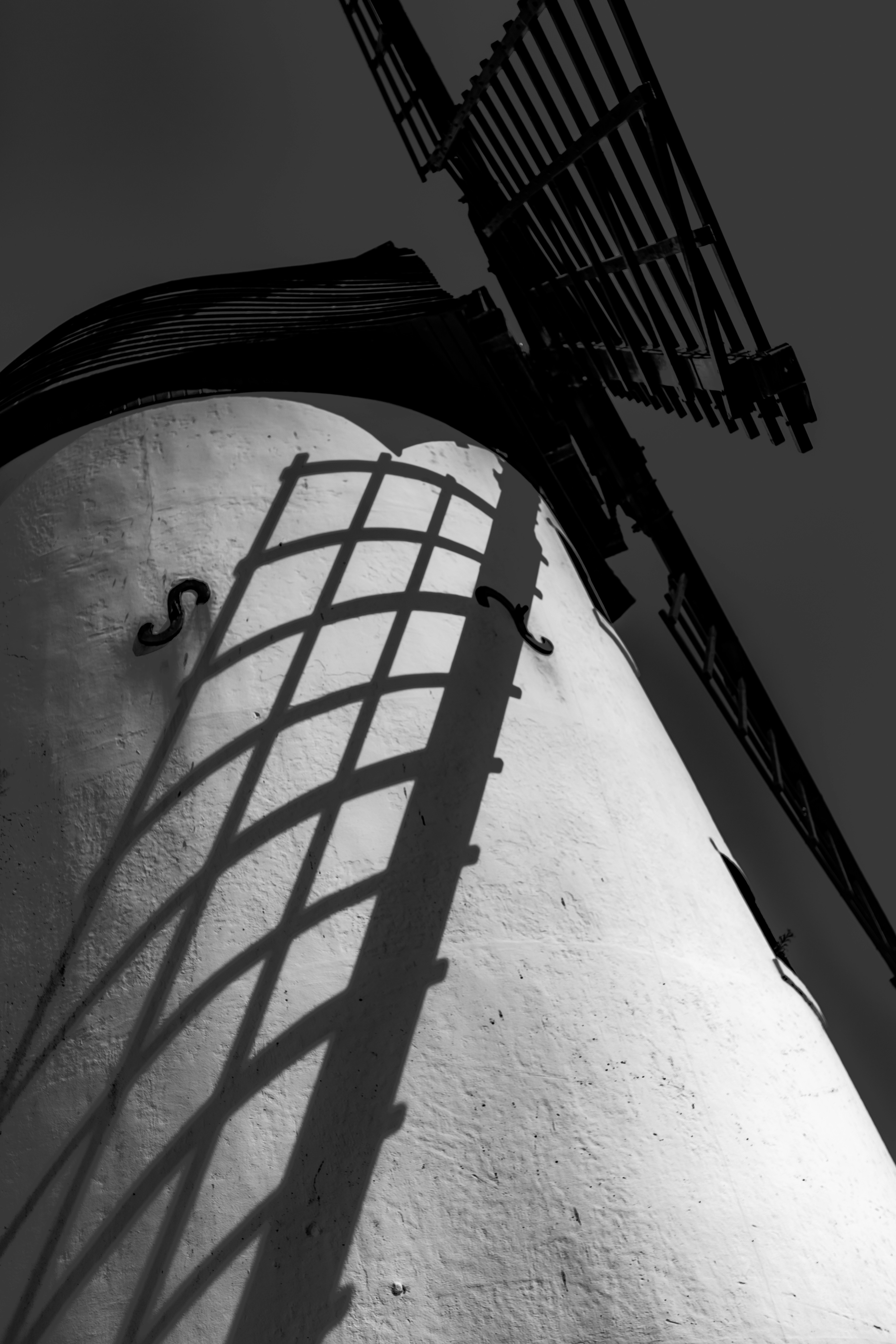 Shadowed Windmill Silhouette on a Tilted Tower