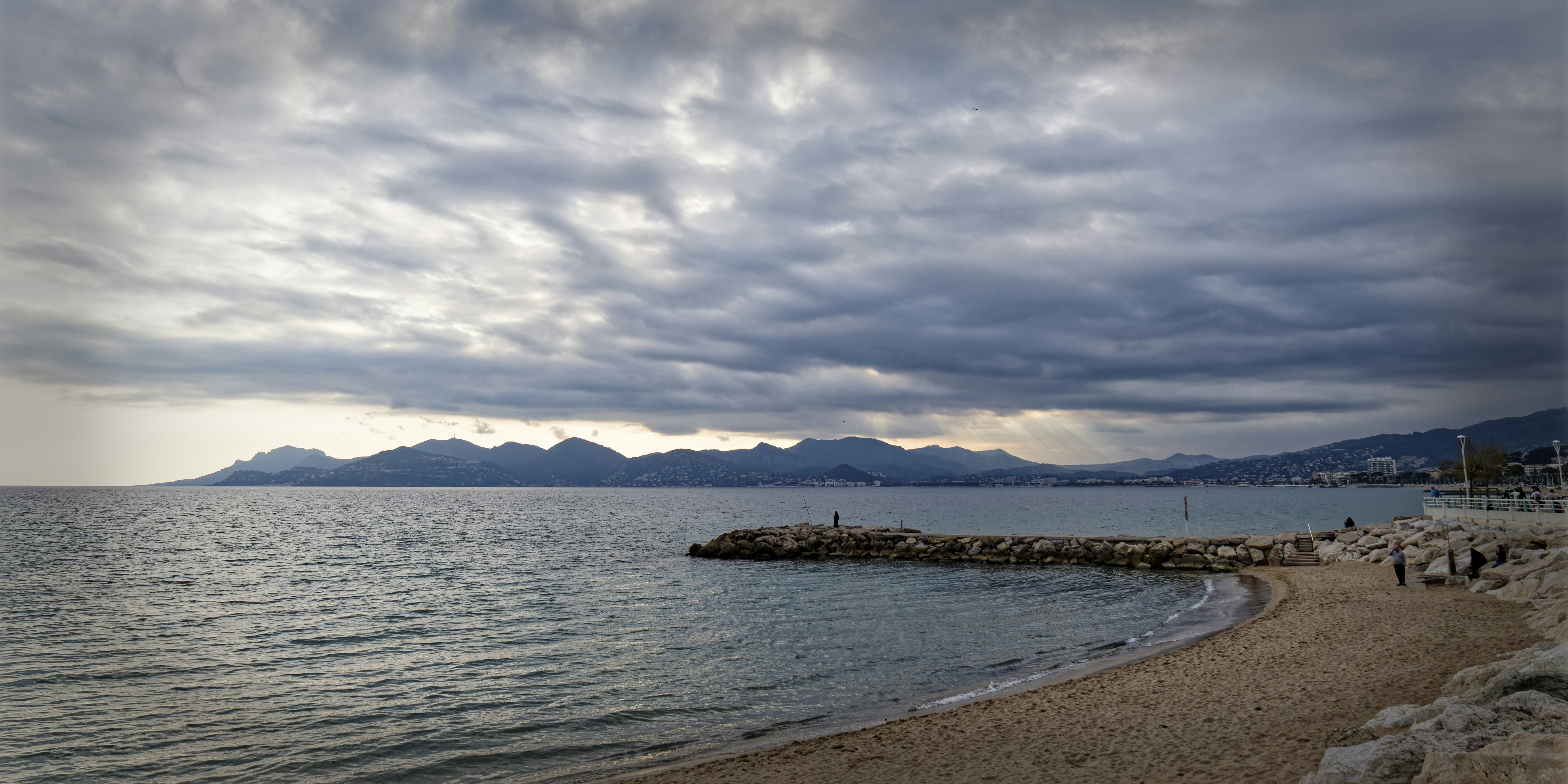 Distant Dunes and Quiet Harbor under a Clouded Sky