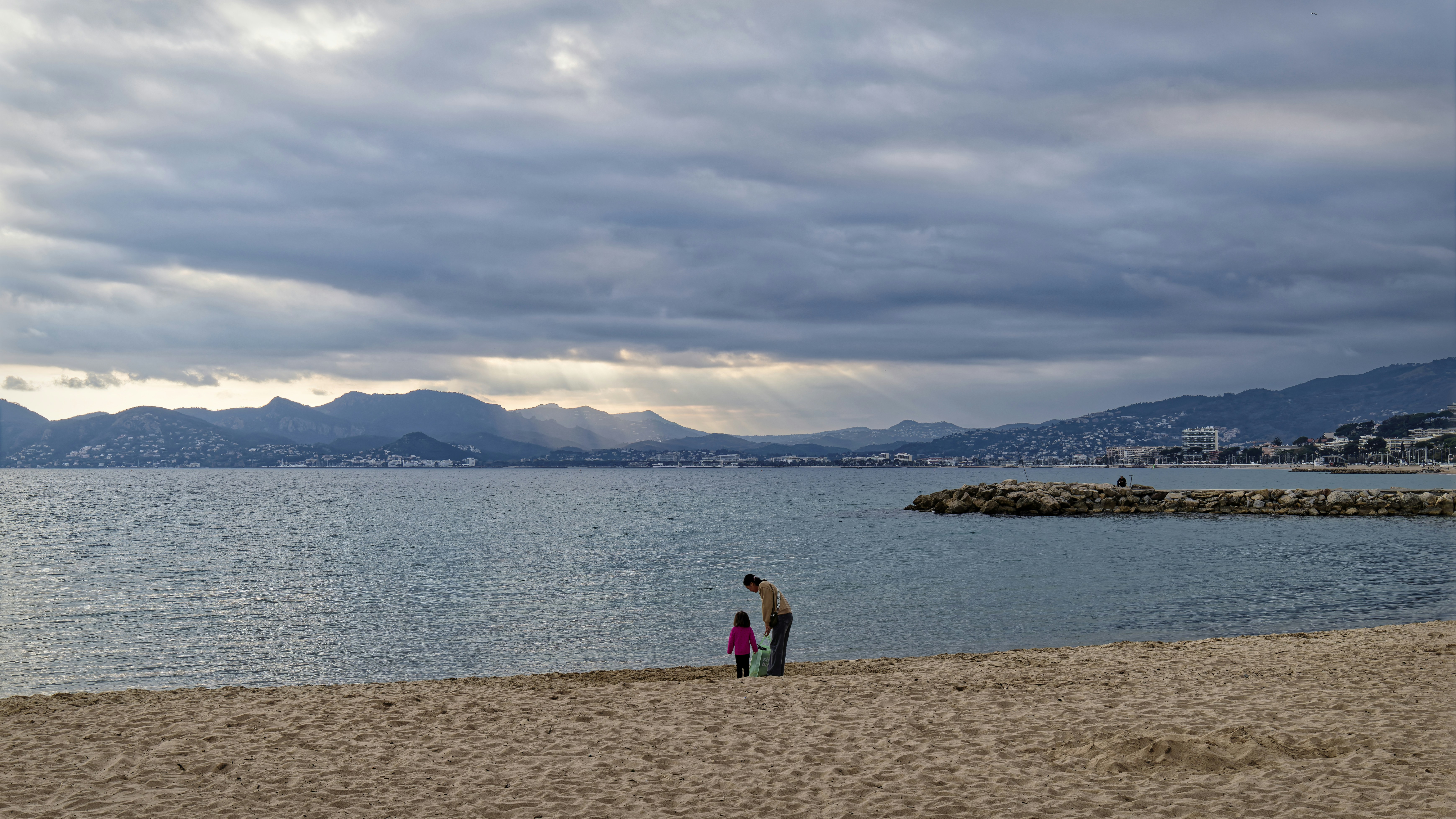 Two silhouettes at the edge of the sea watching the horizon
