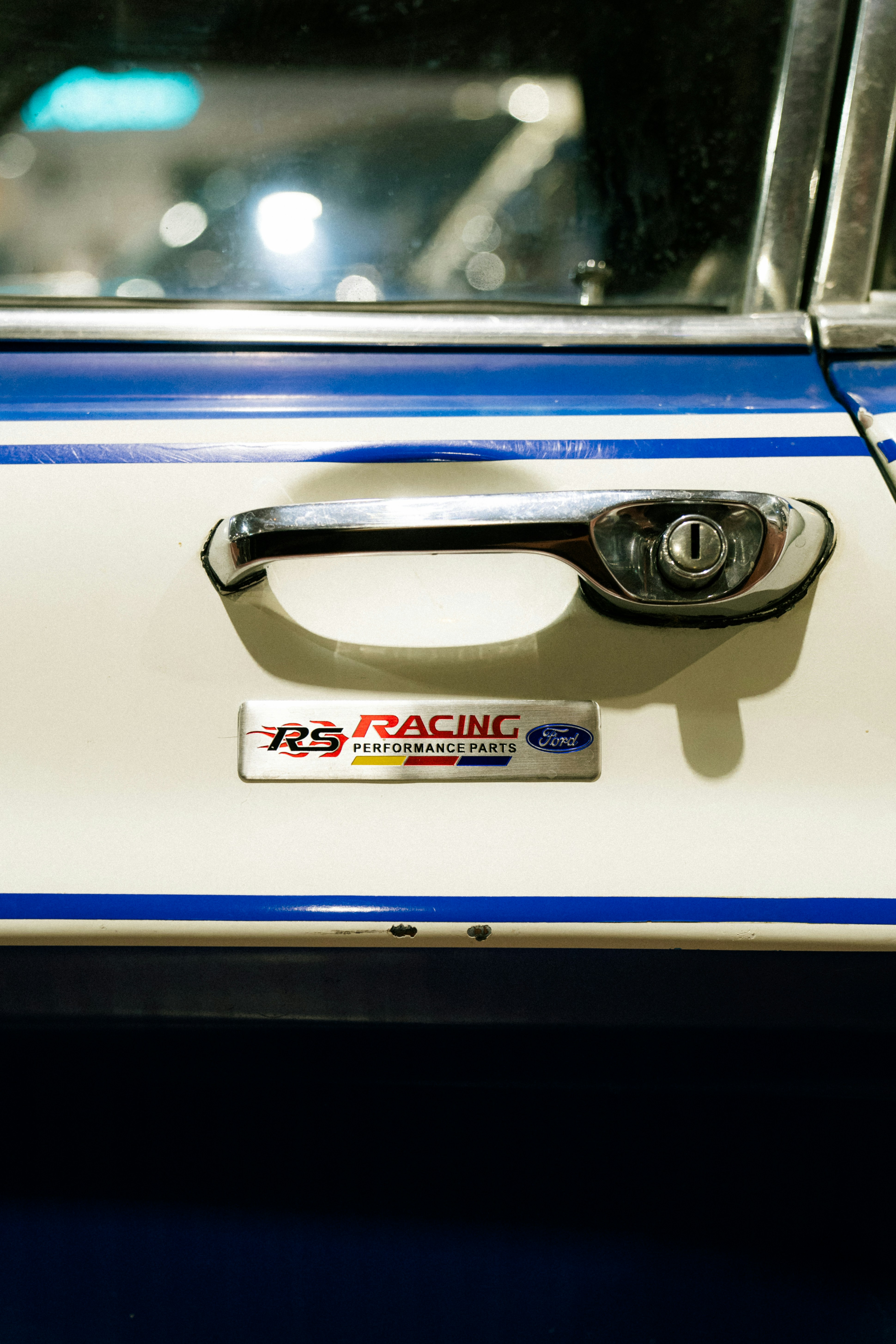 Chrome door handle and RS Racing badge on vintage Ford exterior