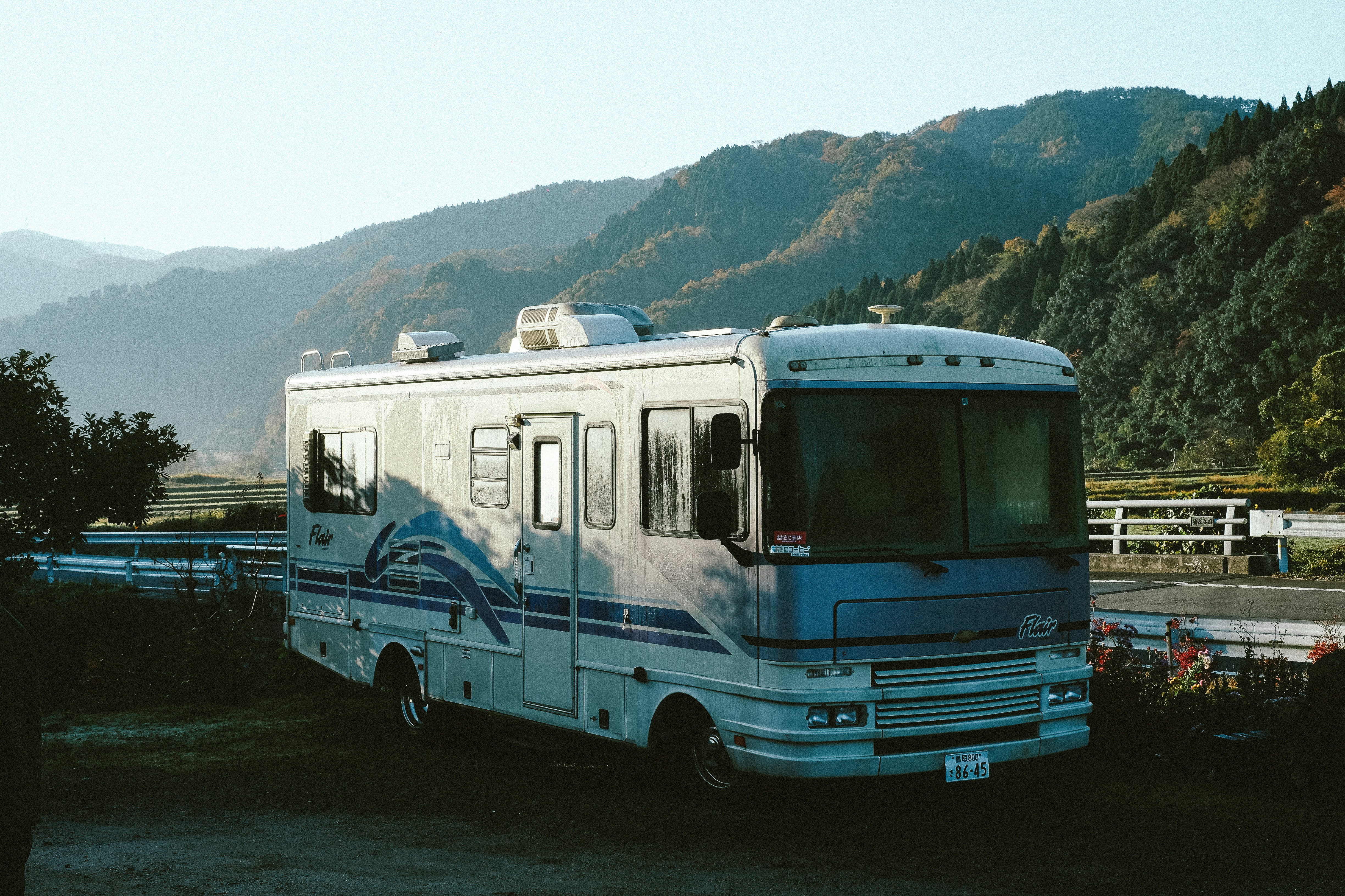 Sunlit RV Rest Stop Amid Mountain Backdrop