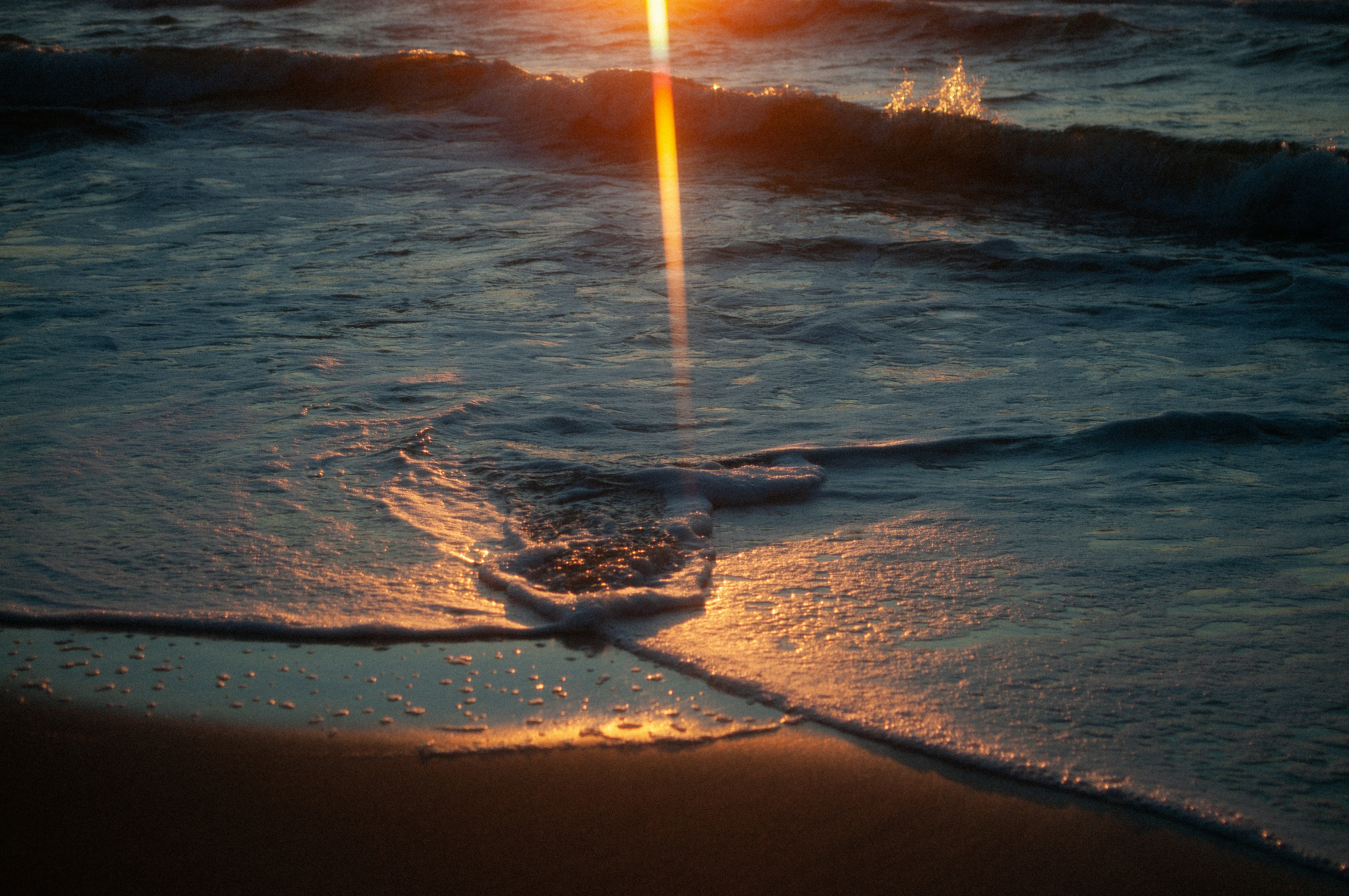 Sunbeam Pierces the Tides: A Quiet Beach at Dusk