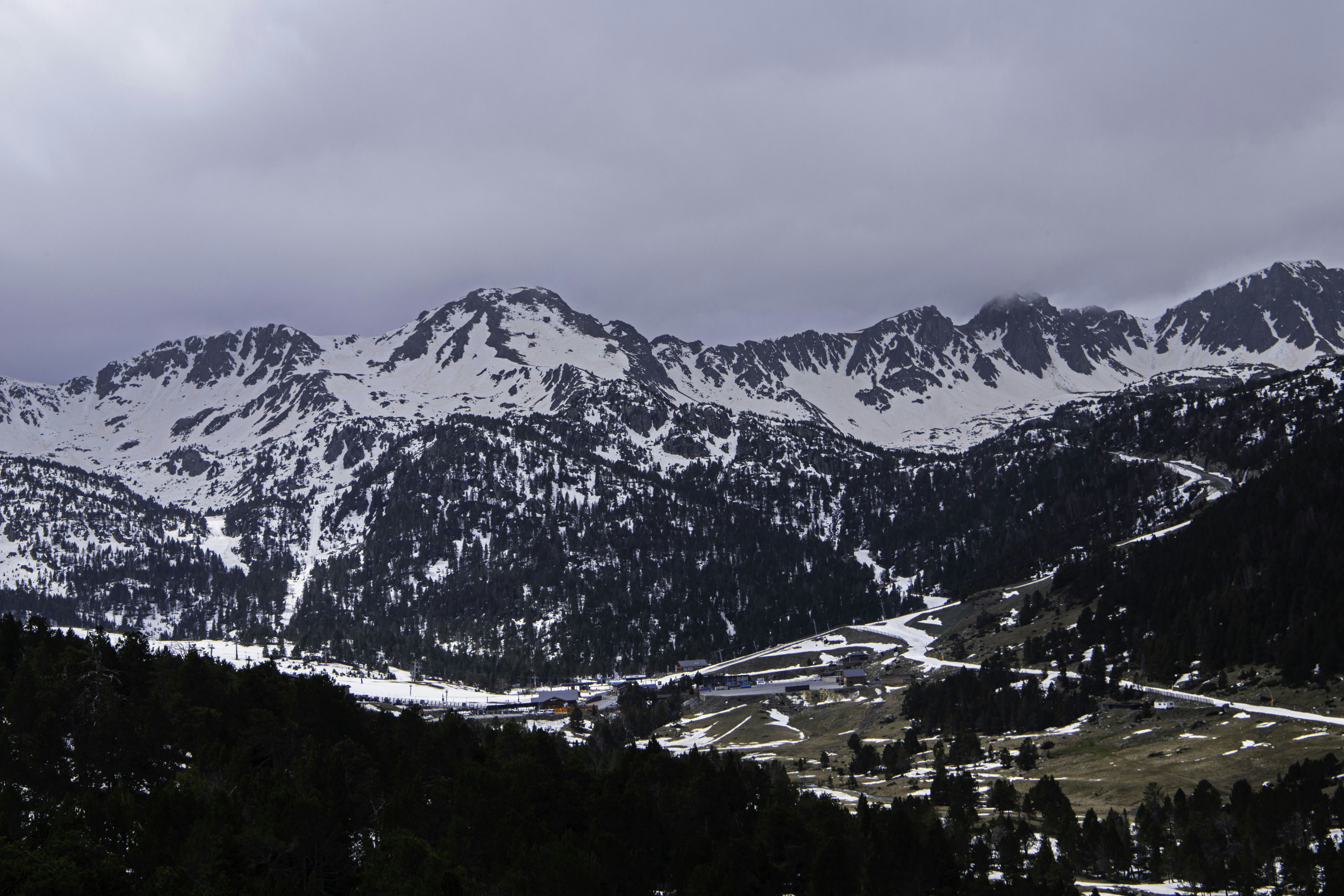 Snow-spotted Alpine Ridge under a Low Cloud Ceiling