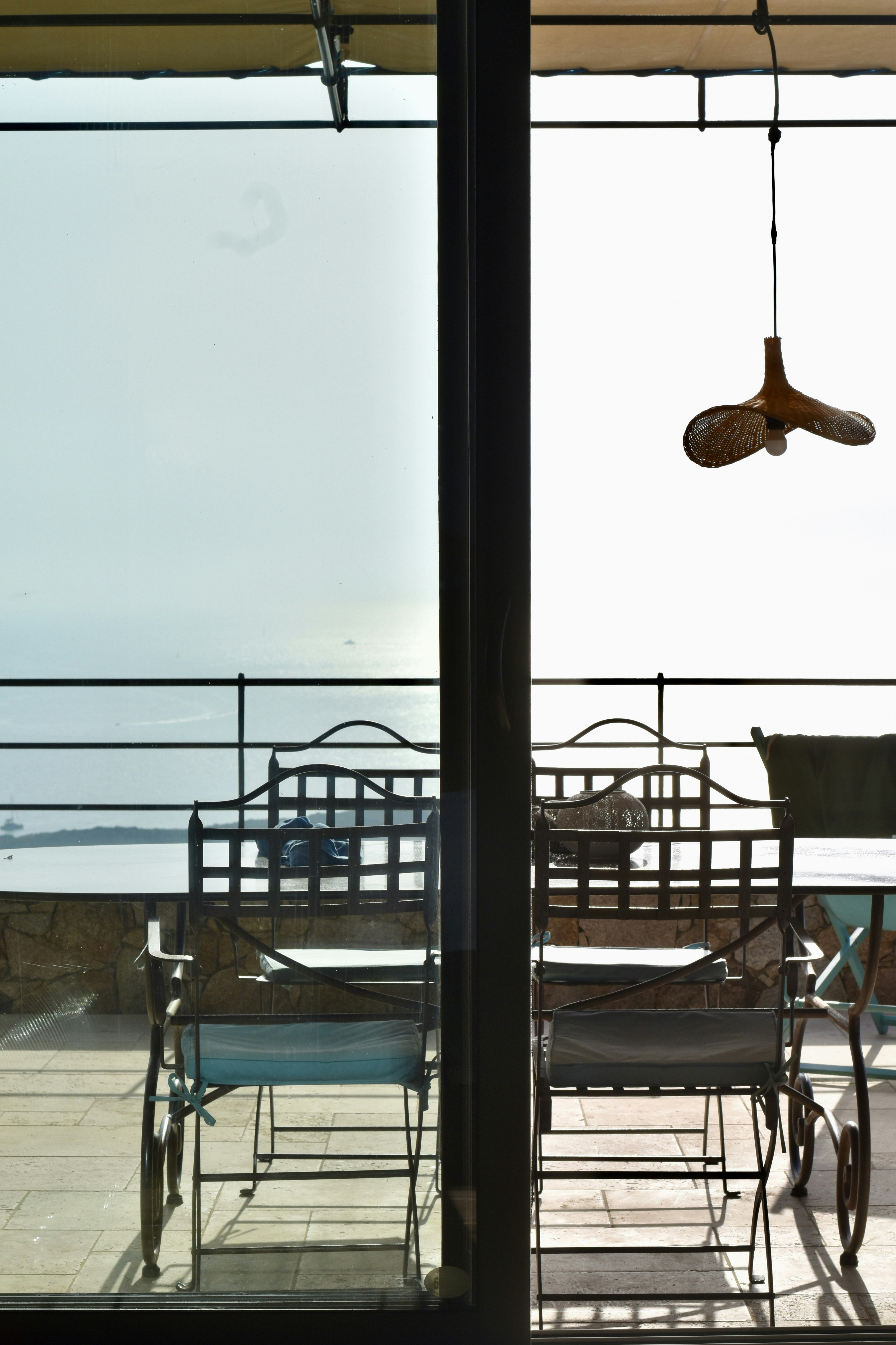 Sunlit Balcony: Empty Chairs Facing the Sea