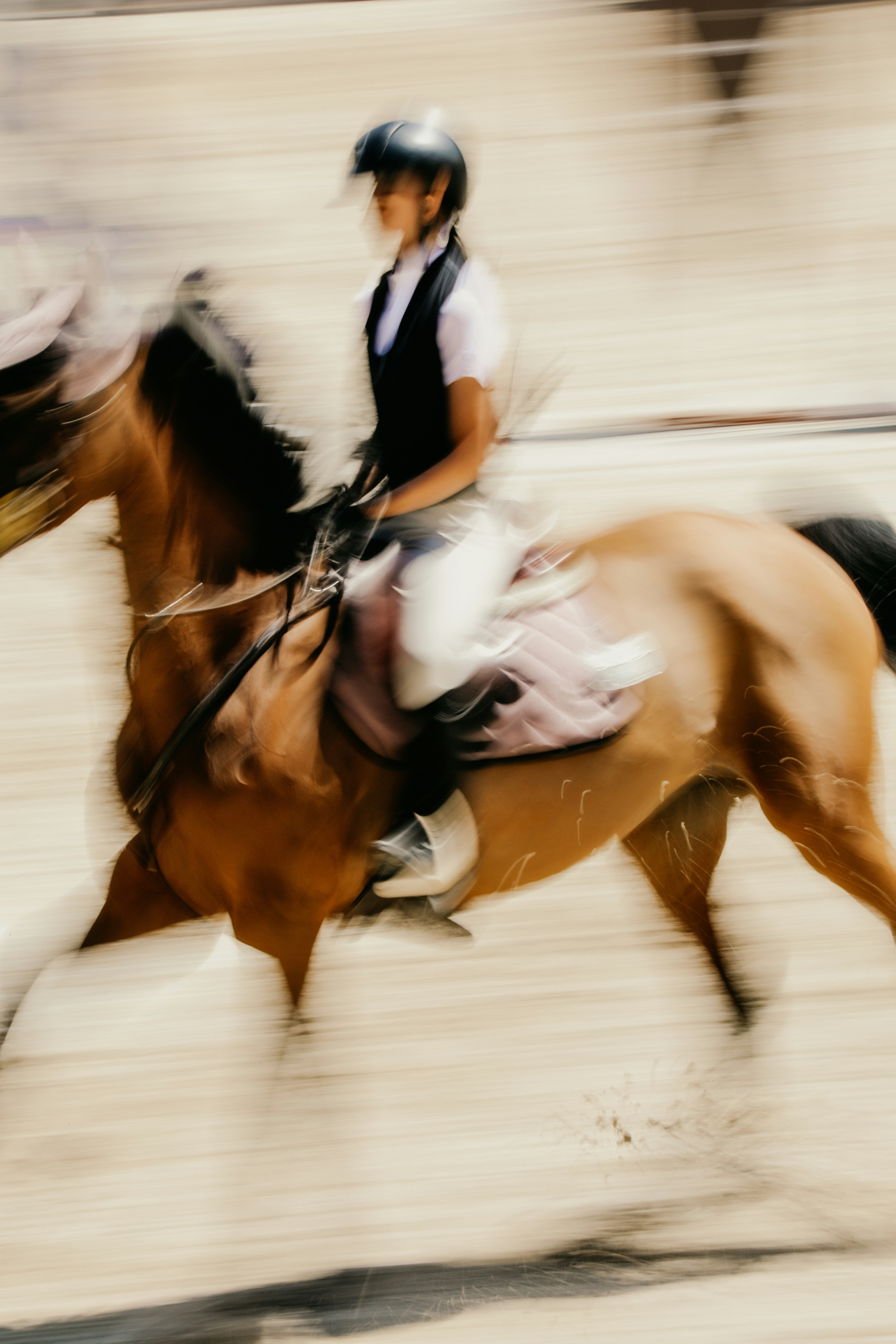 Blurry Cavalcade: Rider in Motion Across Dusty Arena
