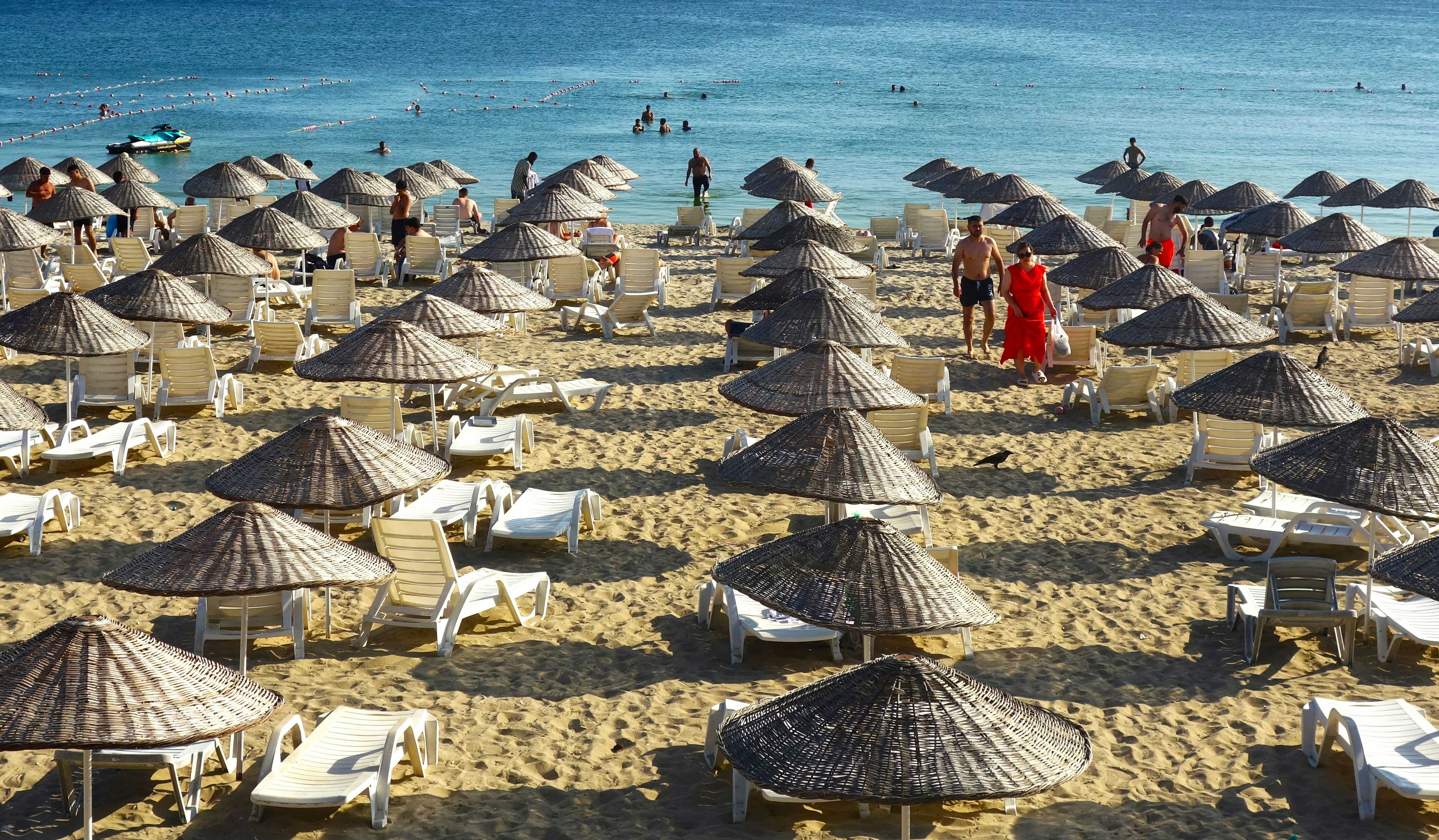 Emerald Beach Pulse: A Sea of Umbrellas and Quiet Figures