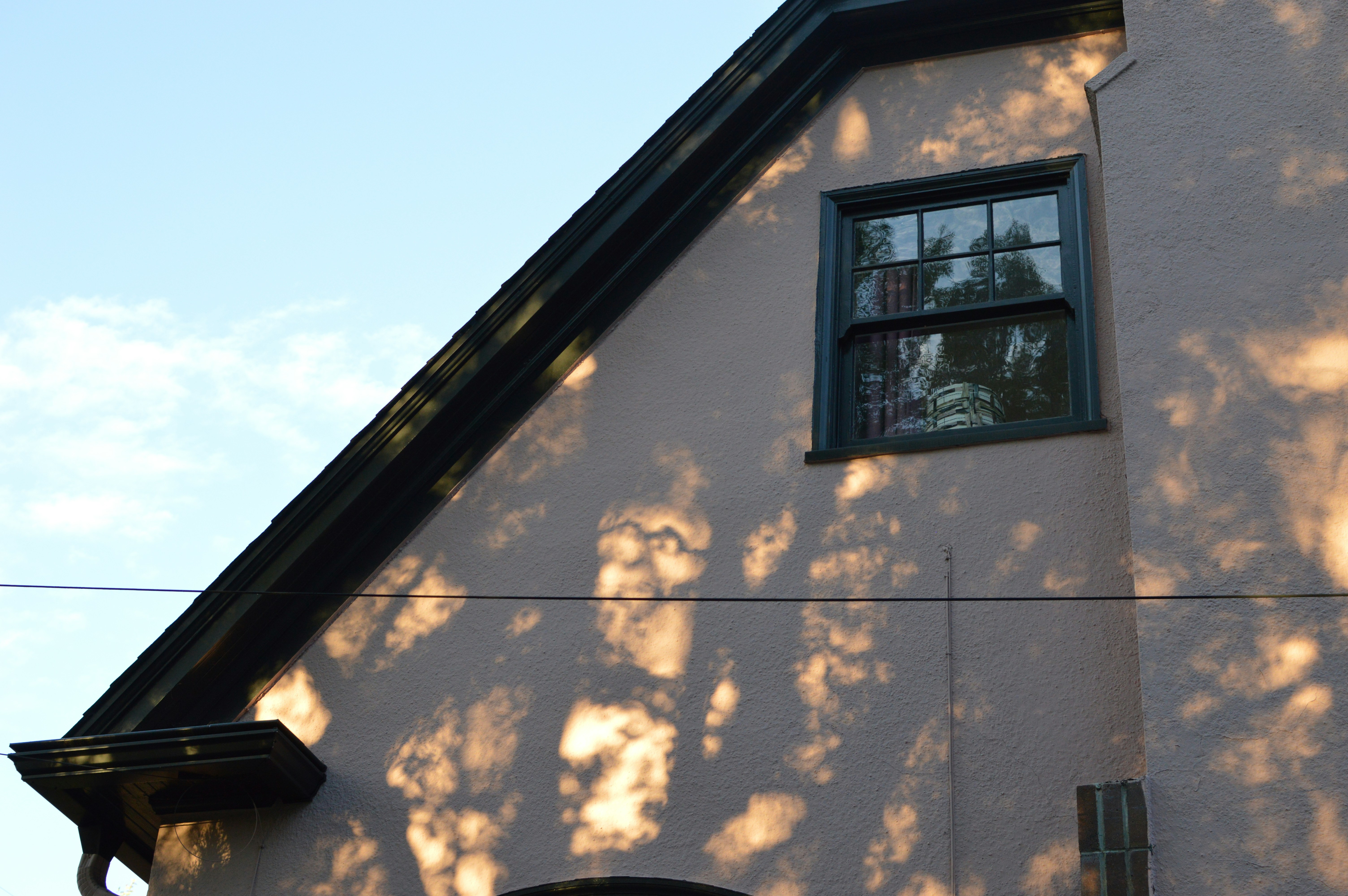 Sunlit Gable: Shadows Dancing Across a Quiet Facade