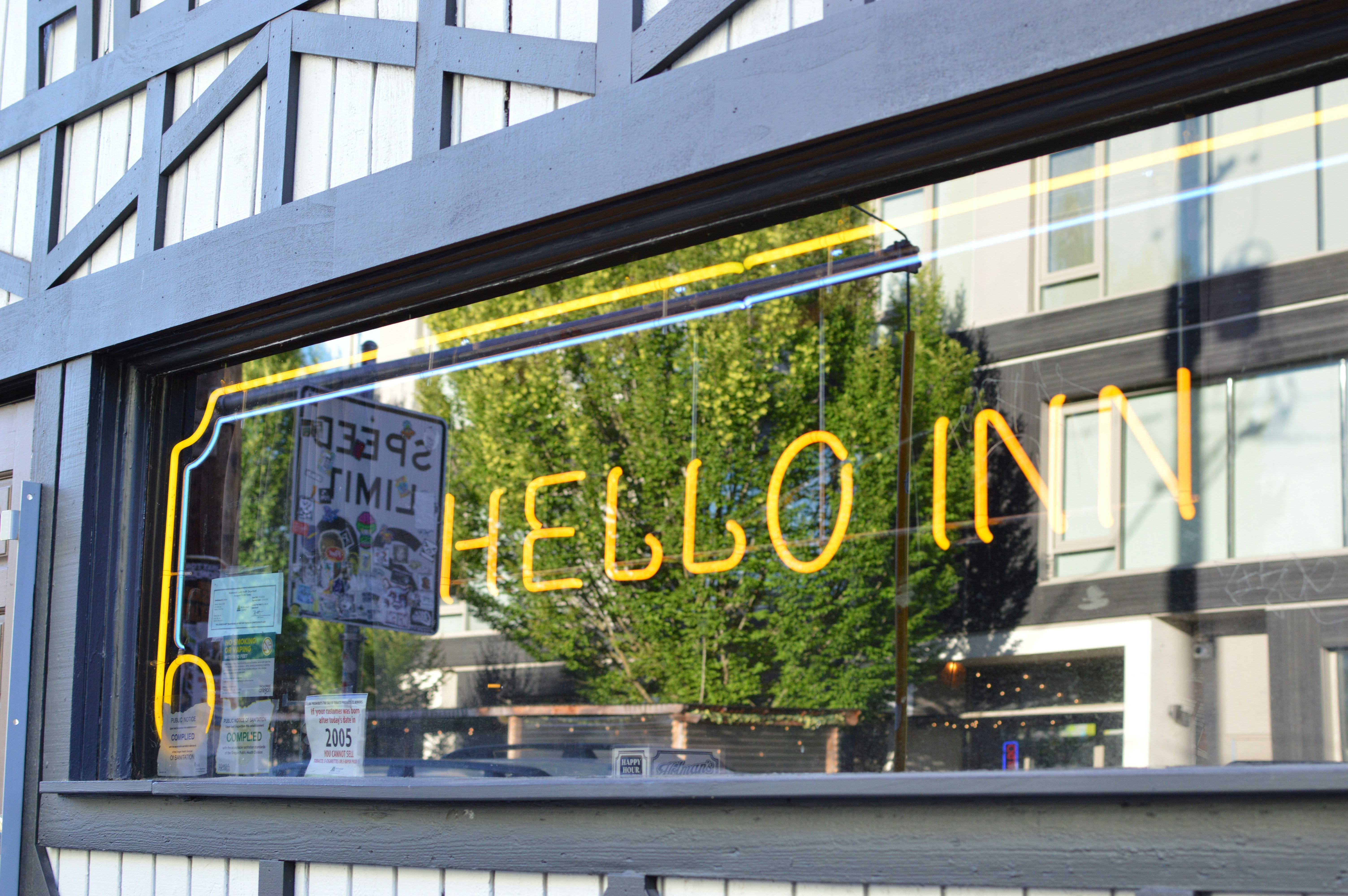 Hello in Neon: Reflective Window Signage Reads a Friendly Greeting