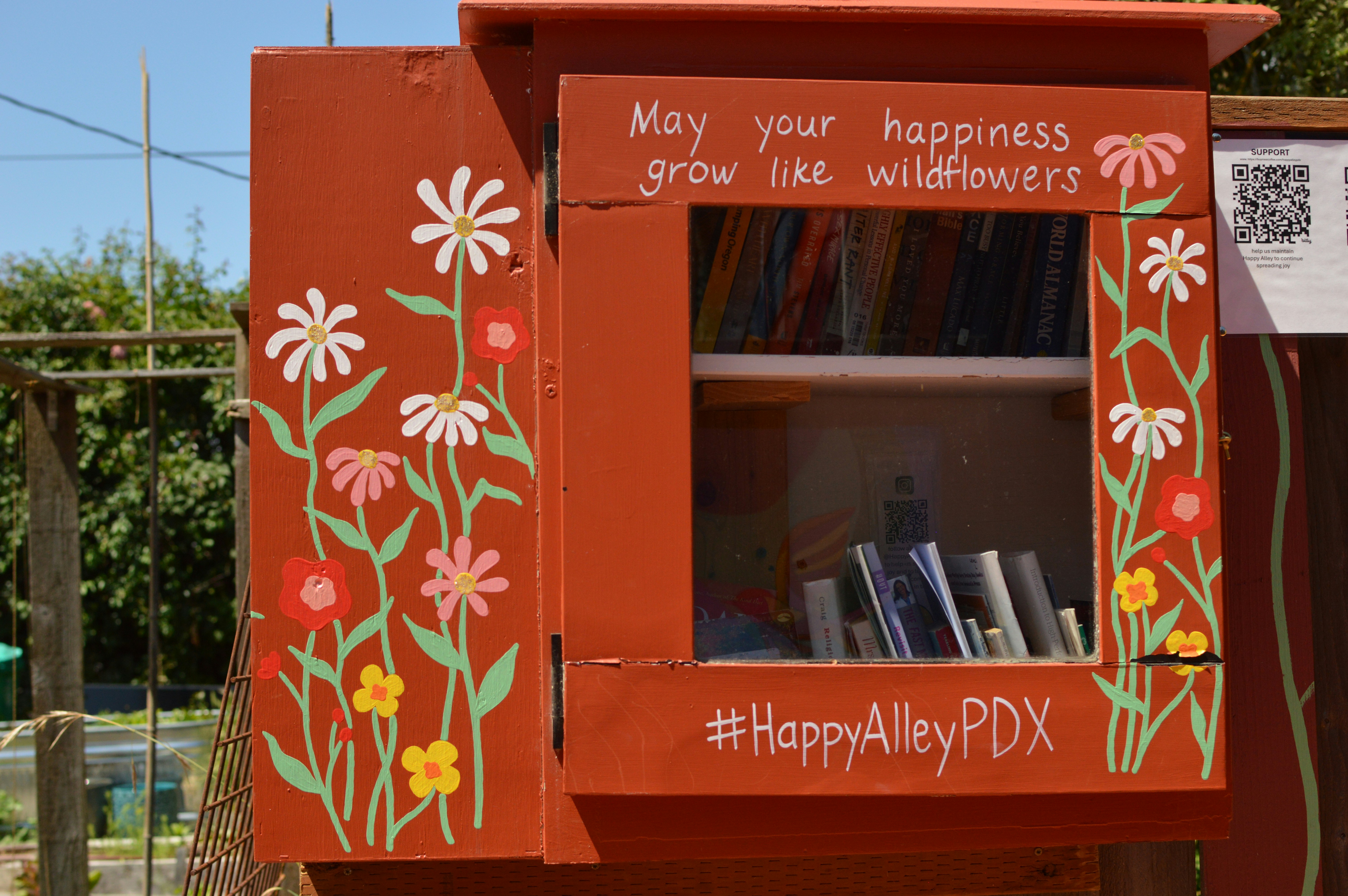 Flowered kiosk of stories: a sunny red hut spilling books