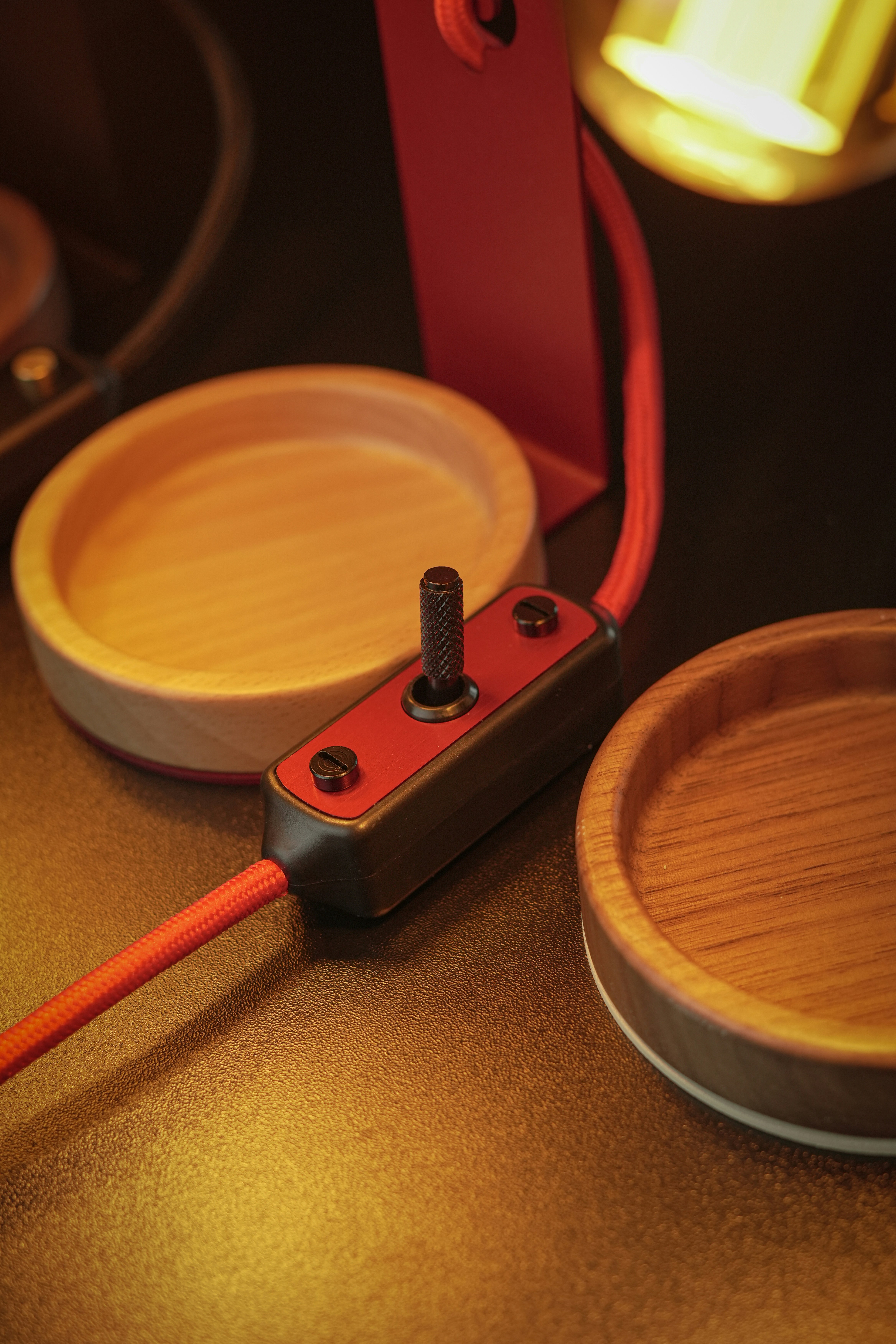 Wire and Wood: A Close-Up on a Lava-Red Switch and Circular Trays