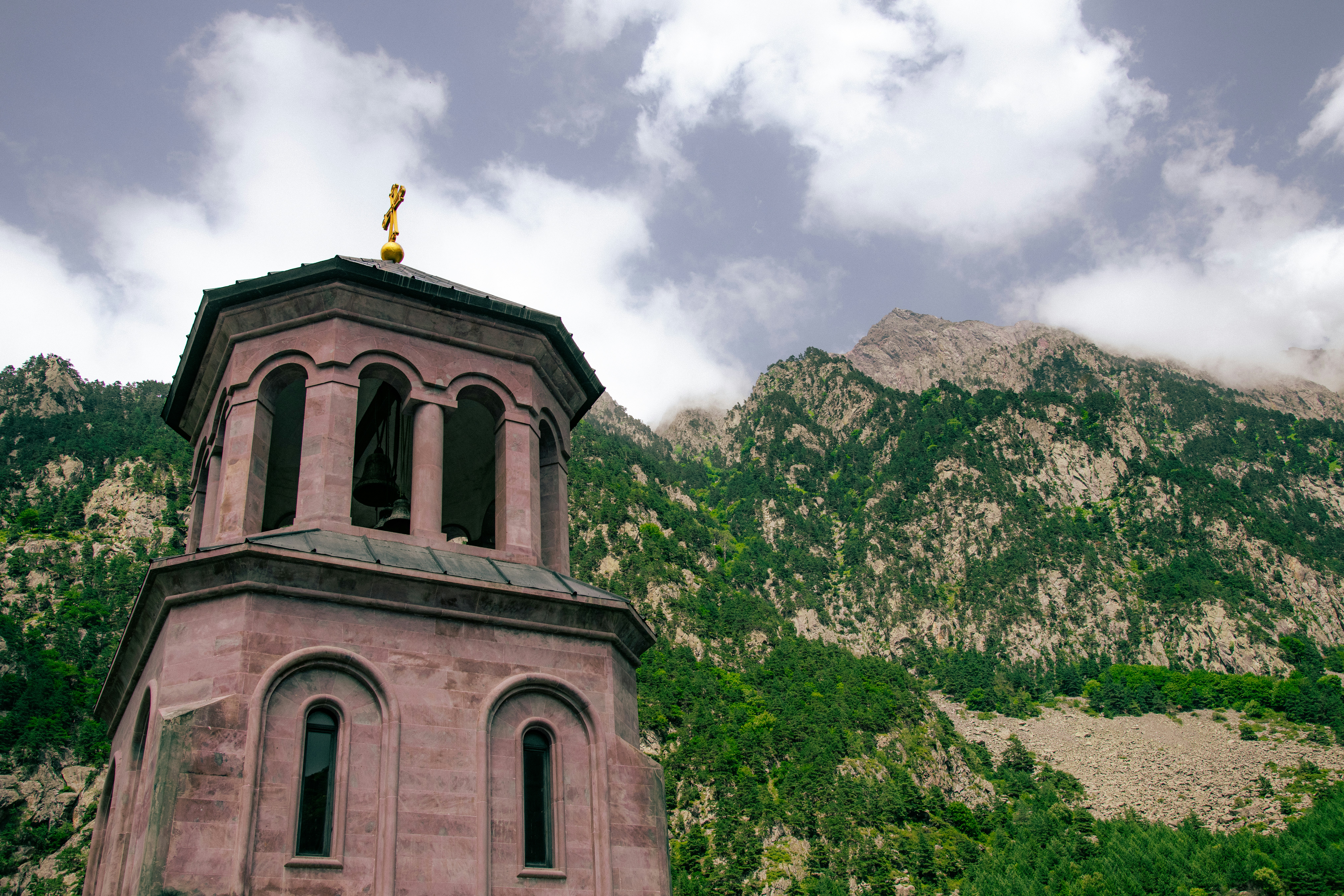 Stone Bell Tower Against Alpine Backdrop