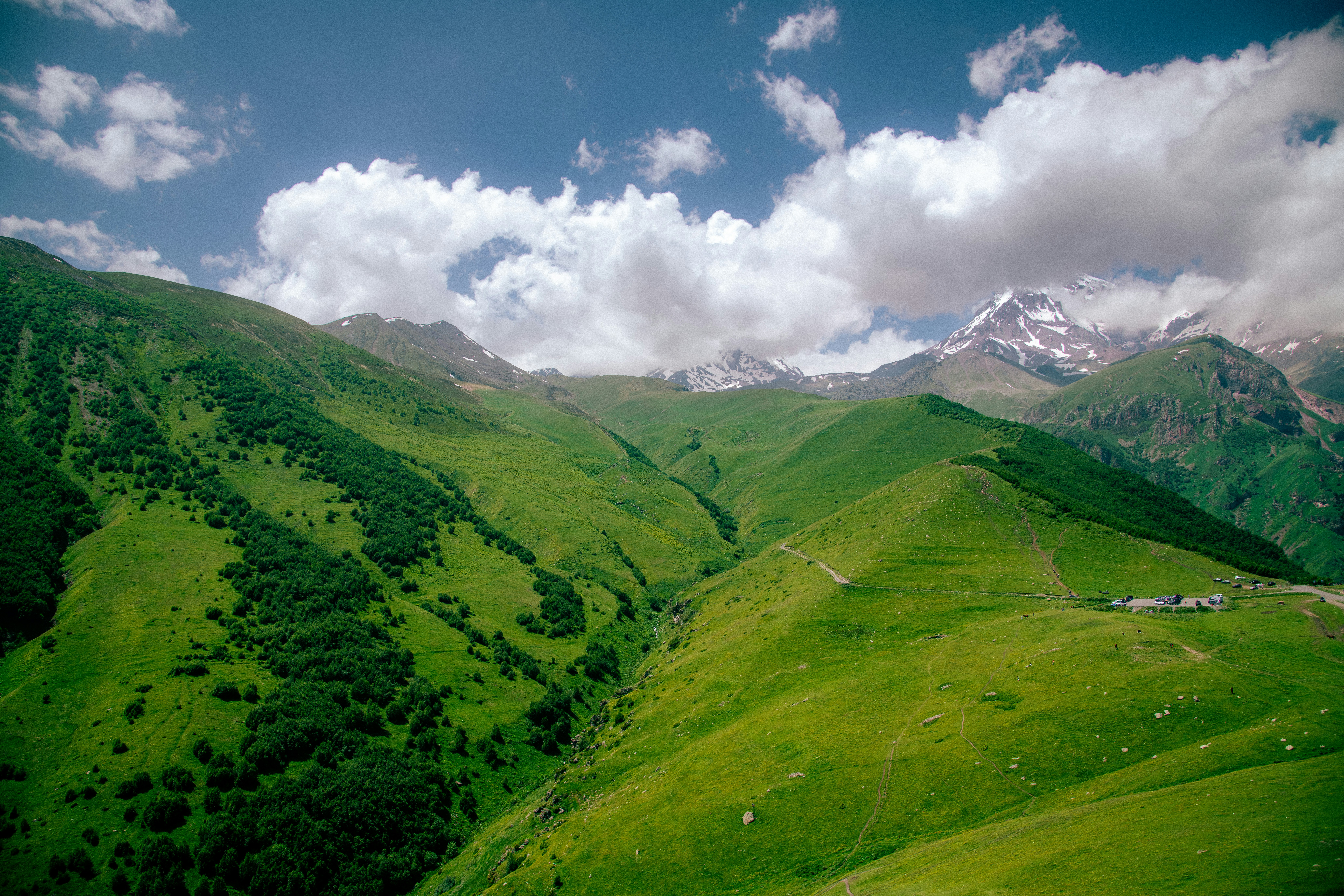 Verdant Spine: Rolling Hills Under a Sky of Cotton Clouds