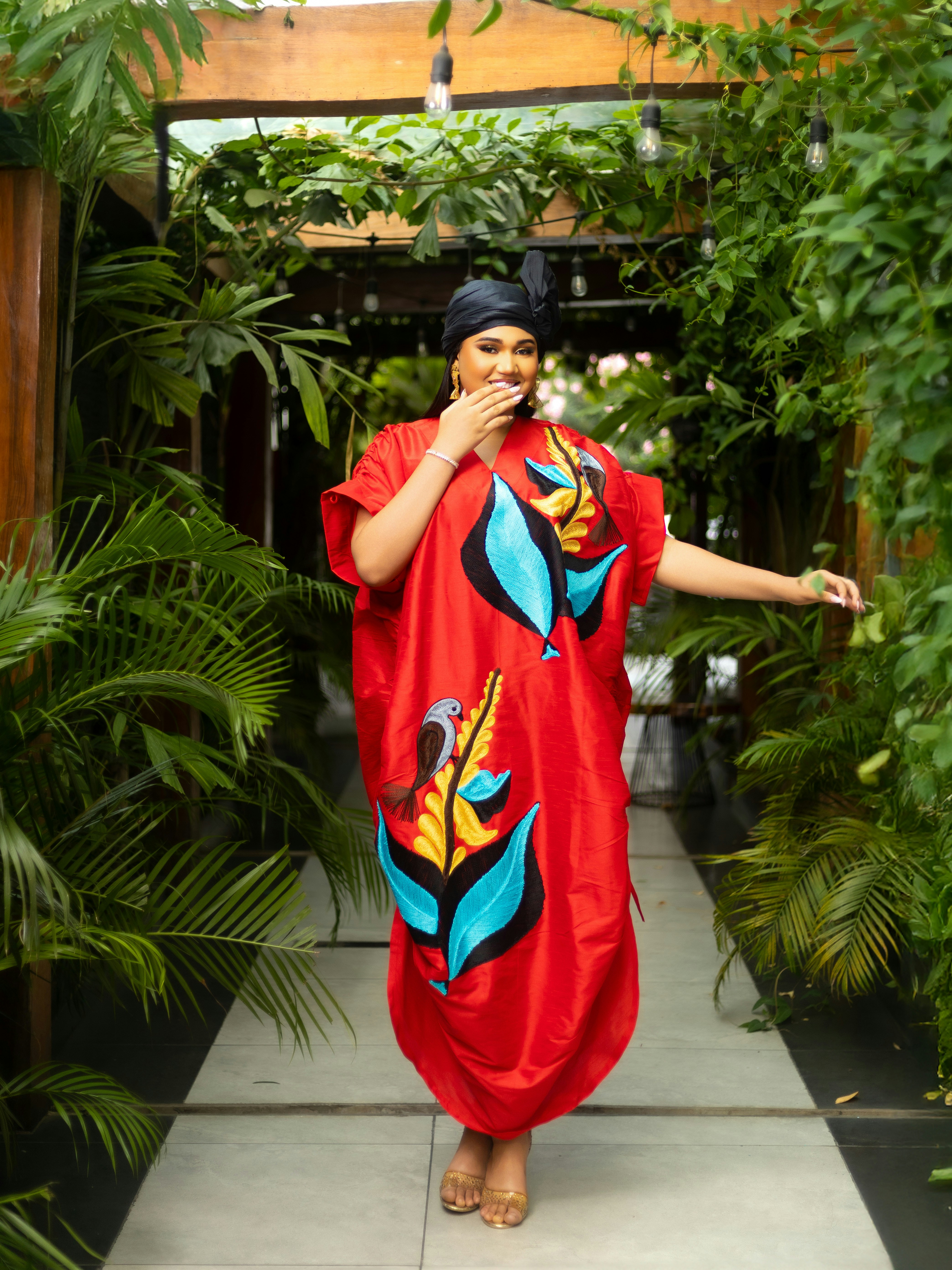 Red robe in a green corridor: a graceful hand-off under hanging bulbs
