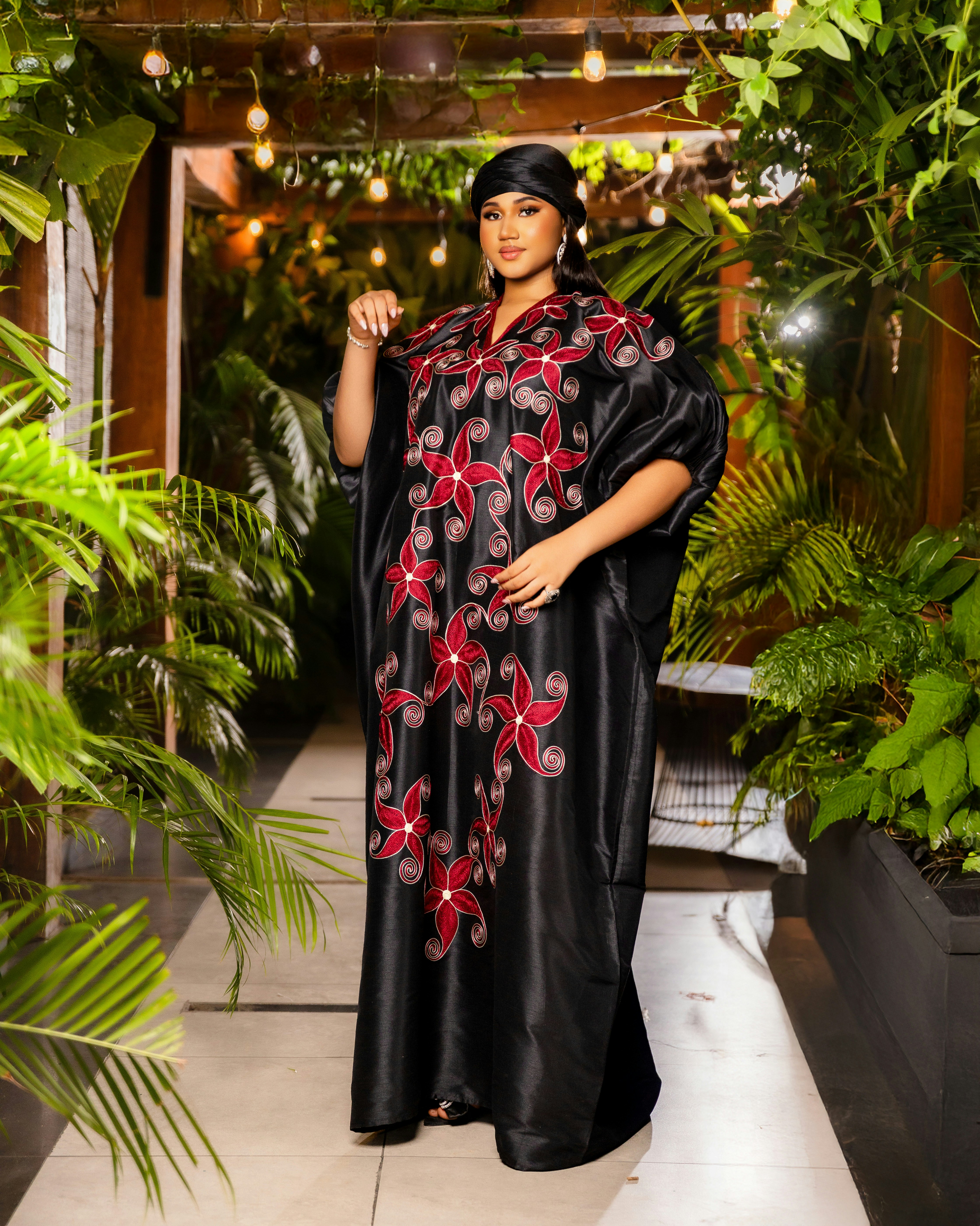 Elegant silhouette in a garden of glow: a flowy black gown with red floral embroidery