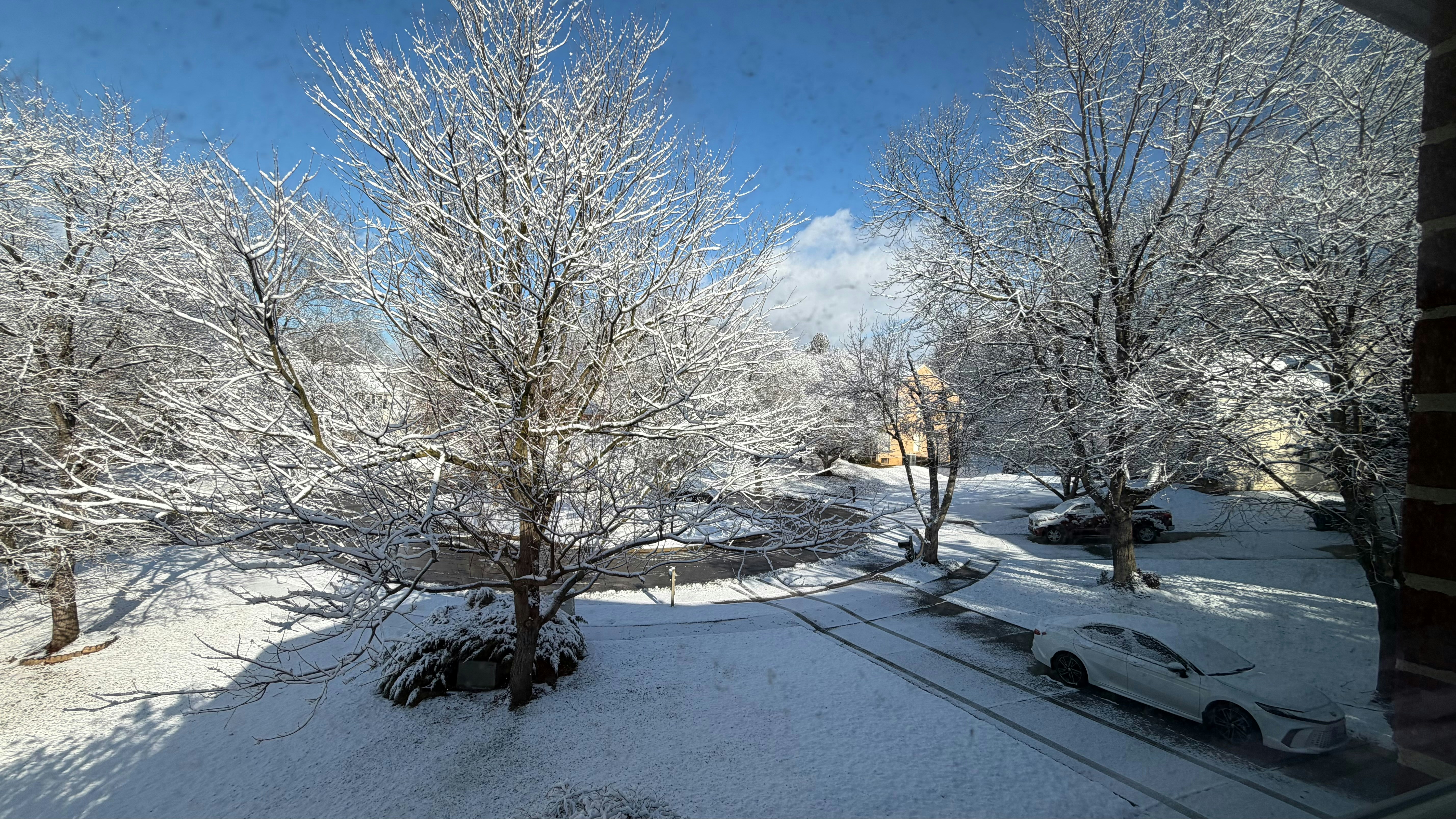 Snow-Covered Courtyard and Parked Car under Bright Winter Sky