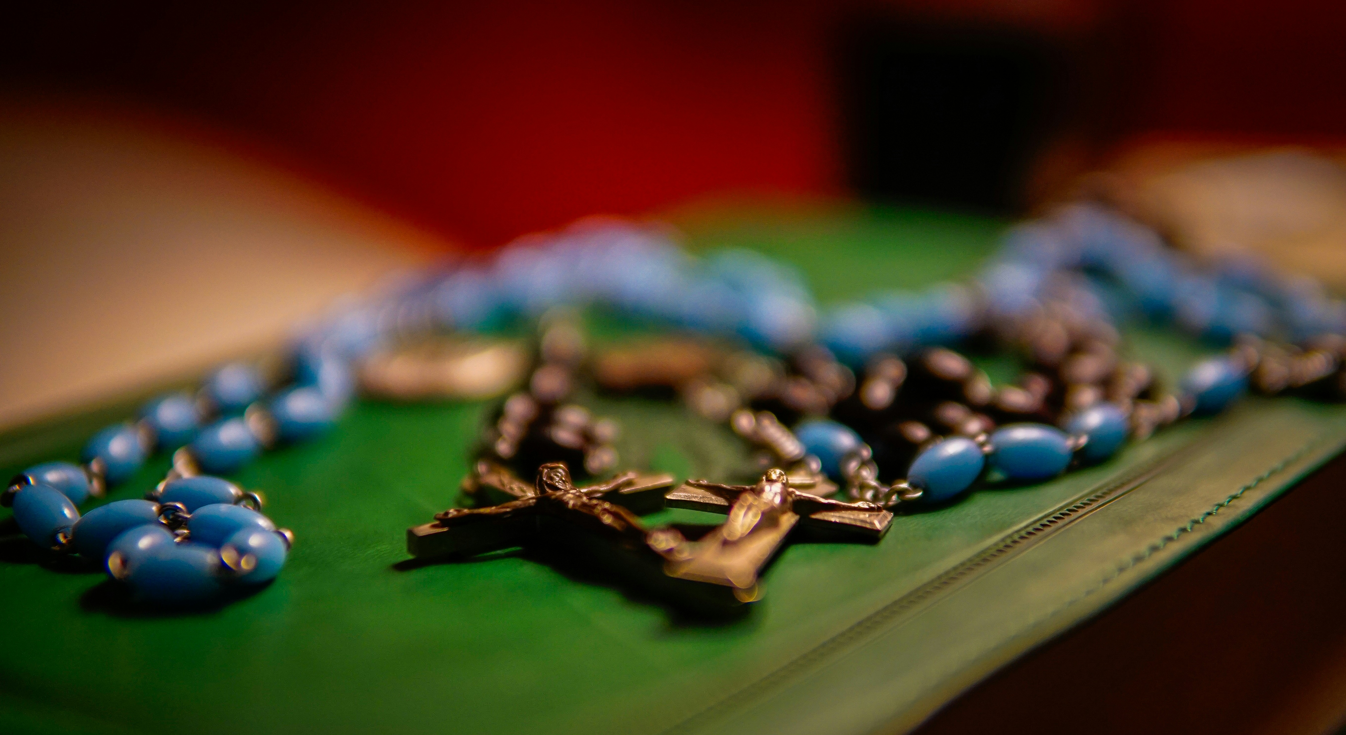 Blue Beads and Cross on a Green Surface