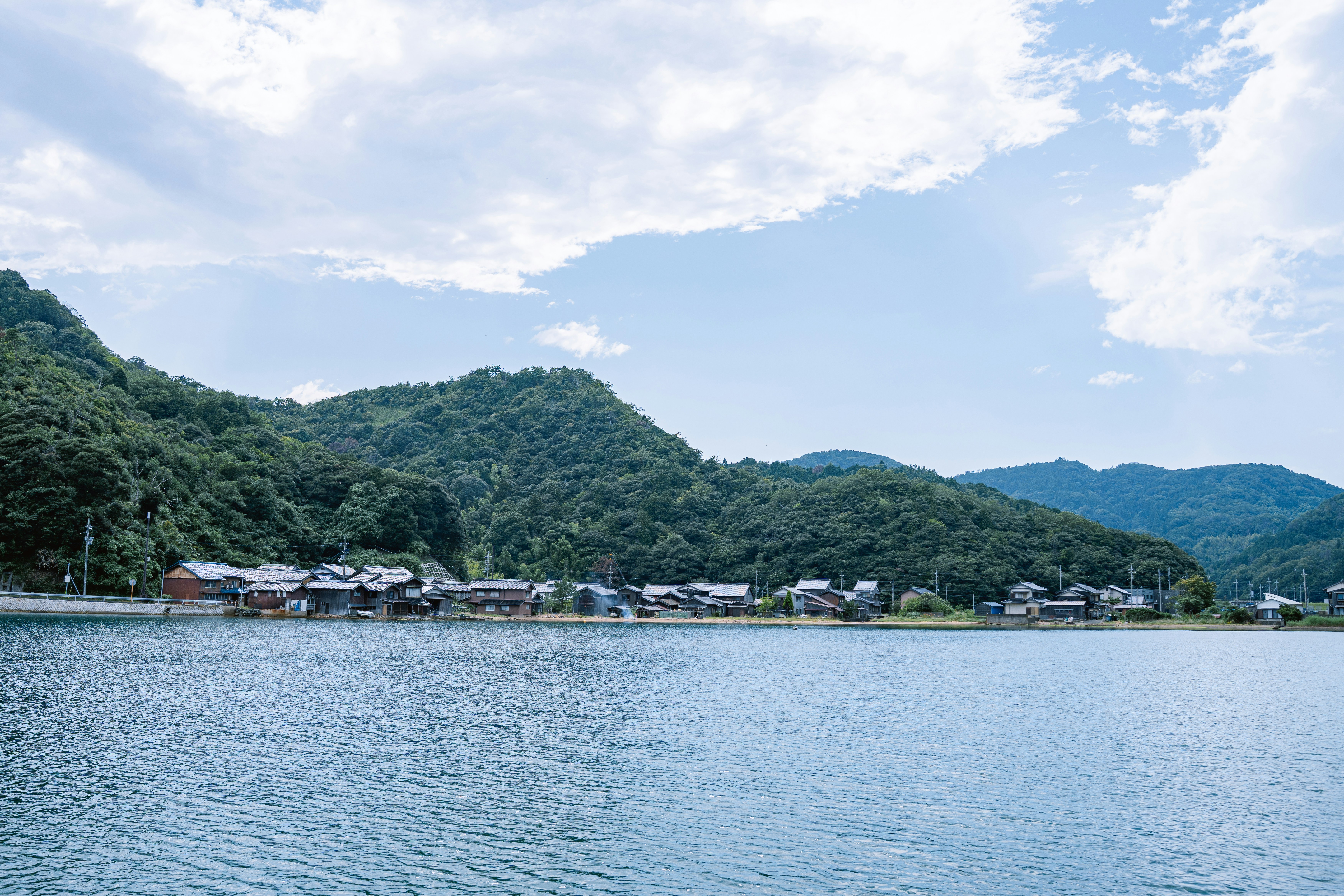 Lakeside Village Embraced by Green Hills under a Gentle Sky