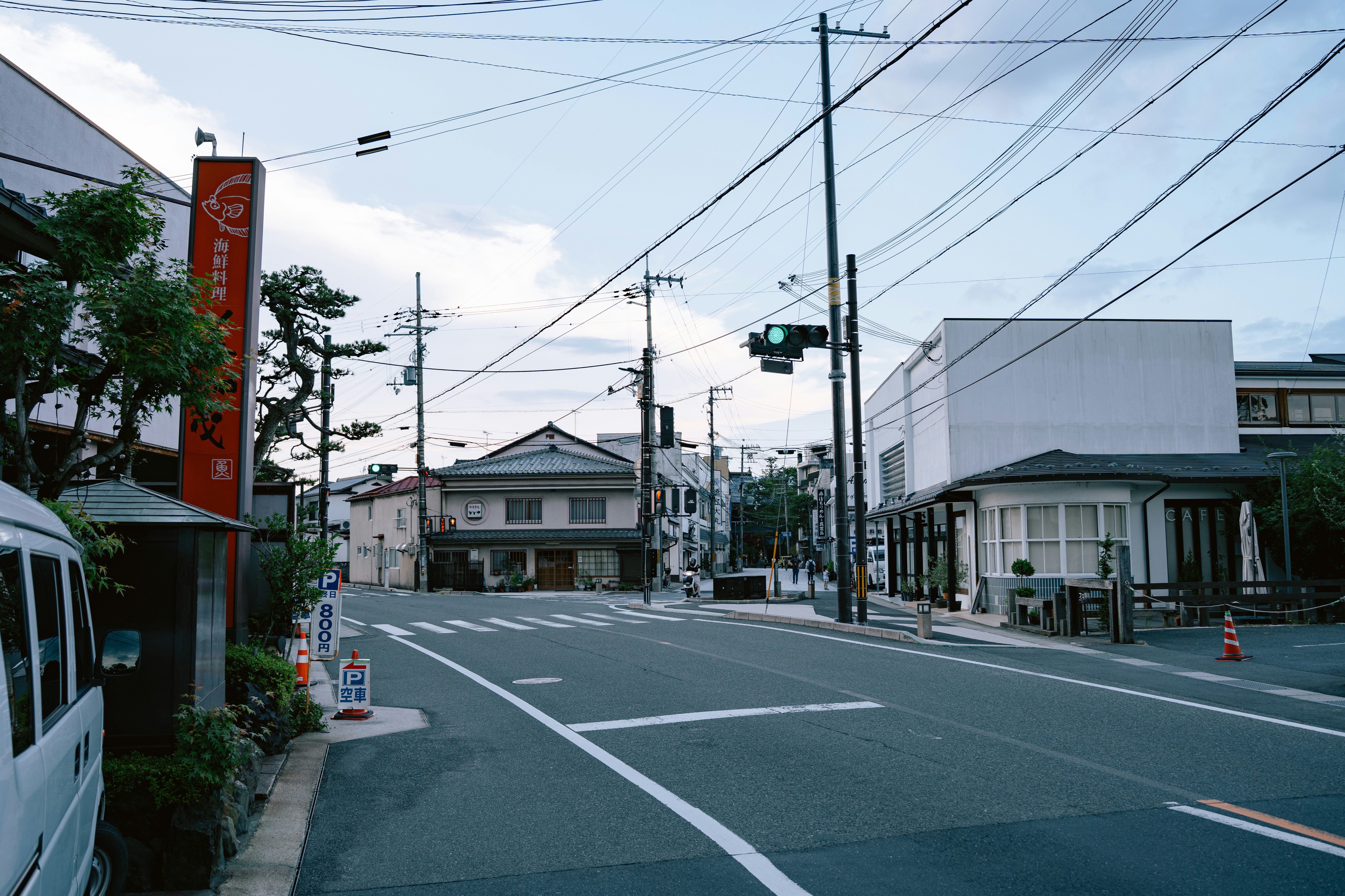 A quiet street intersection with buildings and power lines.