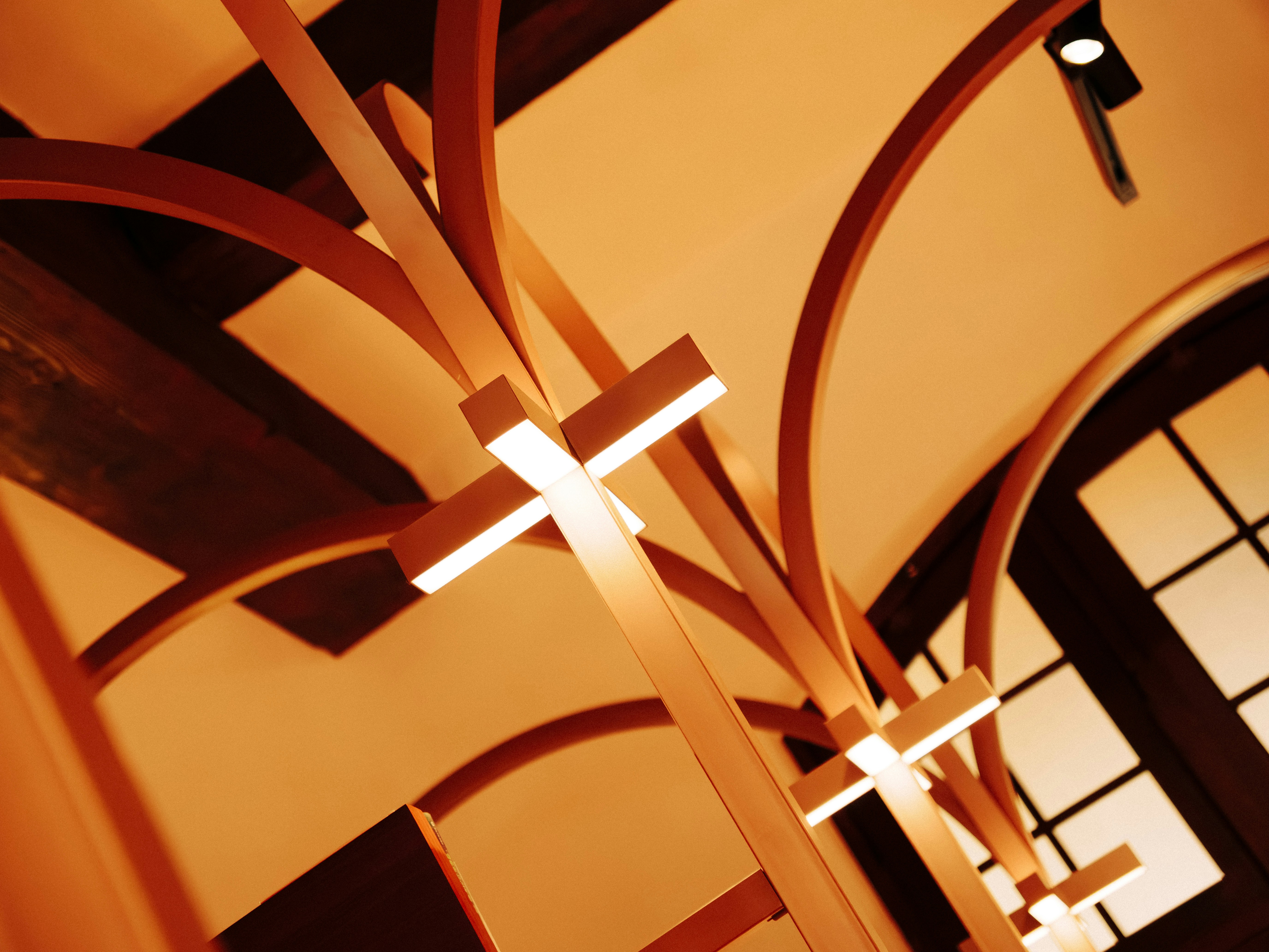 Interwoven arches under warm glow: a sculpted ceiling in motion