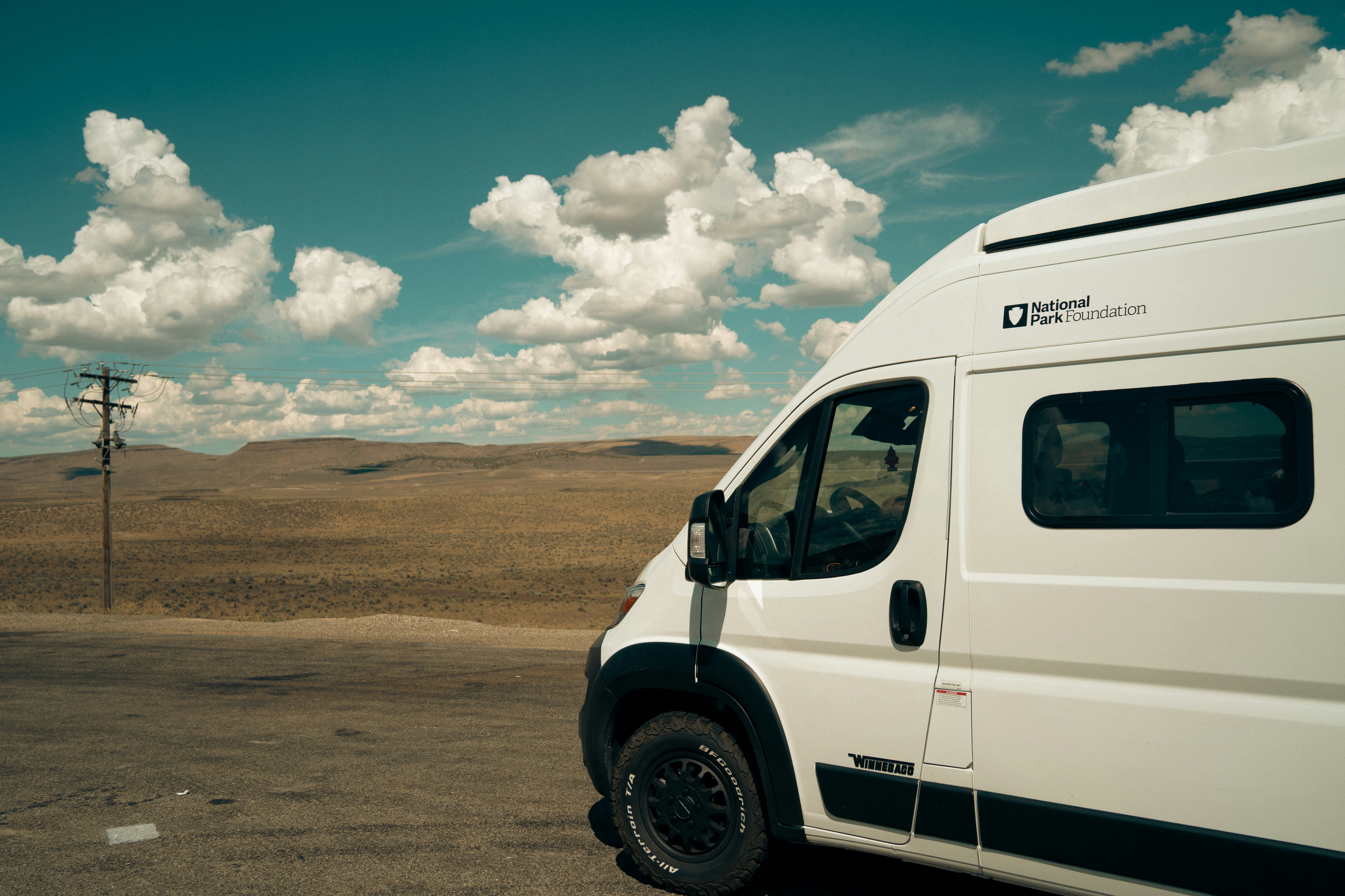 Desert Highway Konvoy: A White Van Against Open Sky