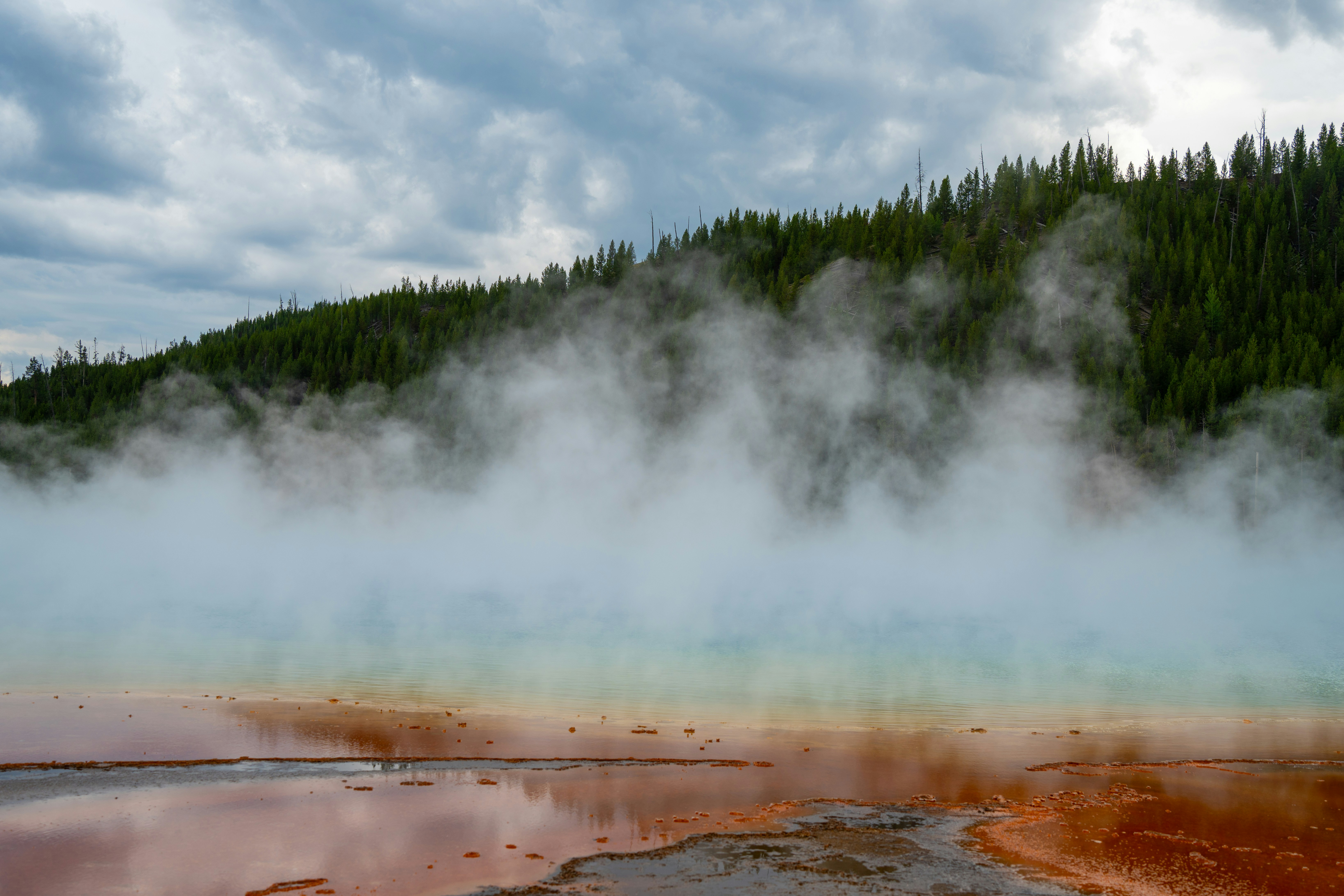 Mist over the mineral terraces: cobalt blue vapor and sunset colors at the edge of a geothermal pool