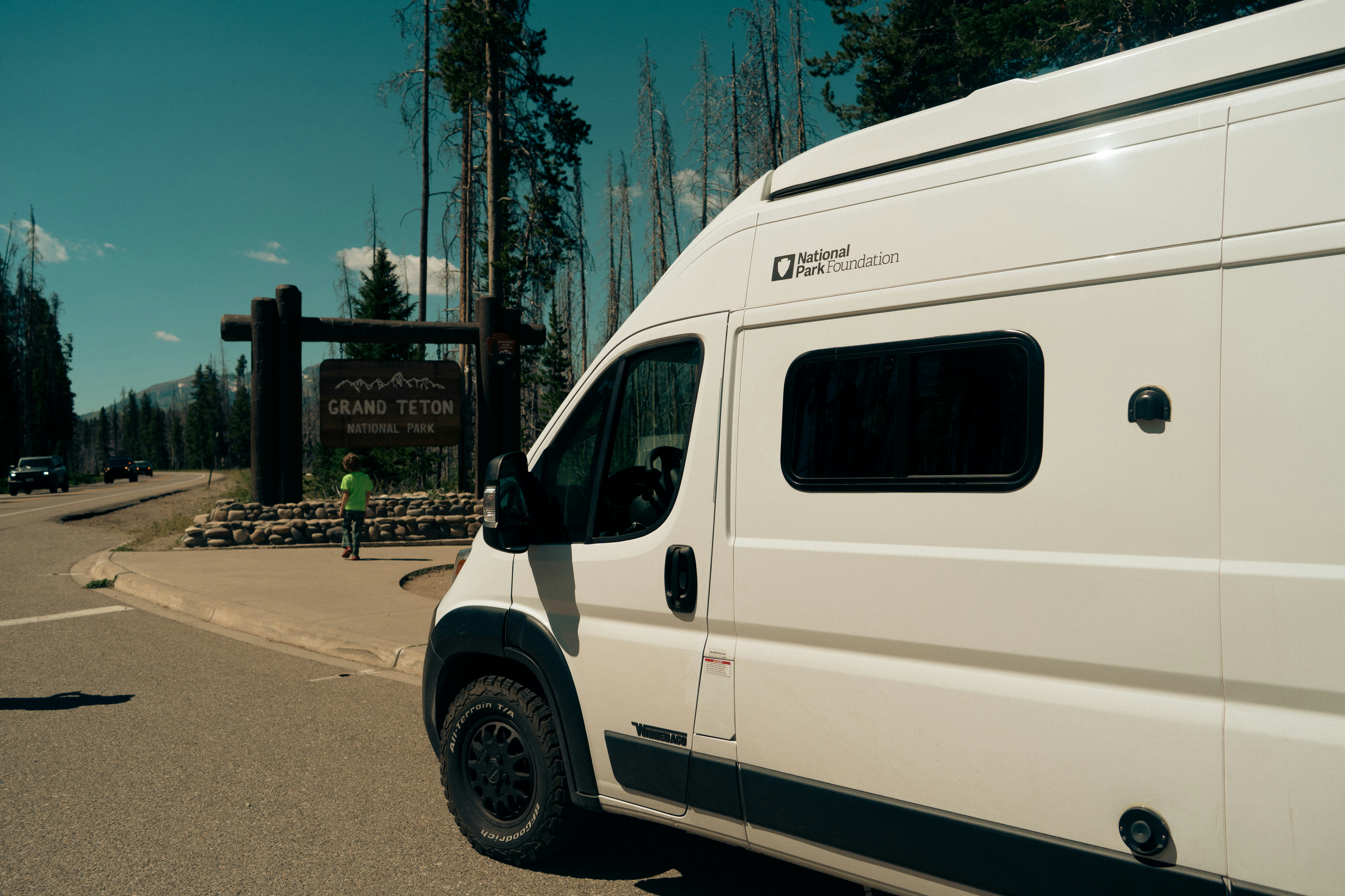 White van at the national park entrance under a clear blue sky