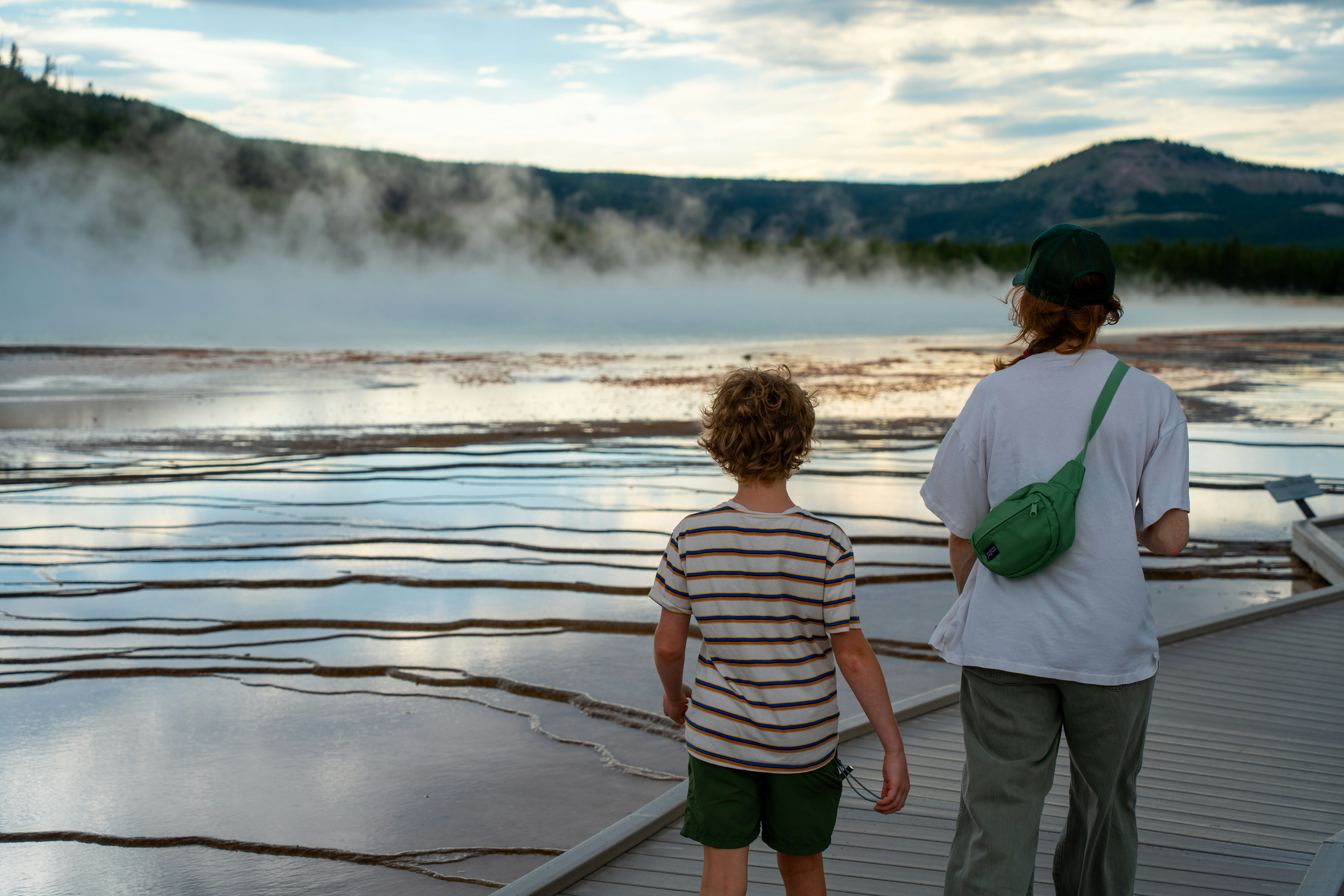Steam-lit Boardwalk toward a Misty Thermal Field