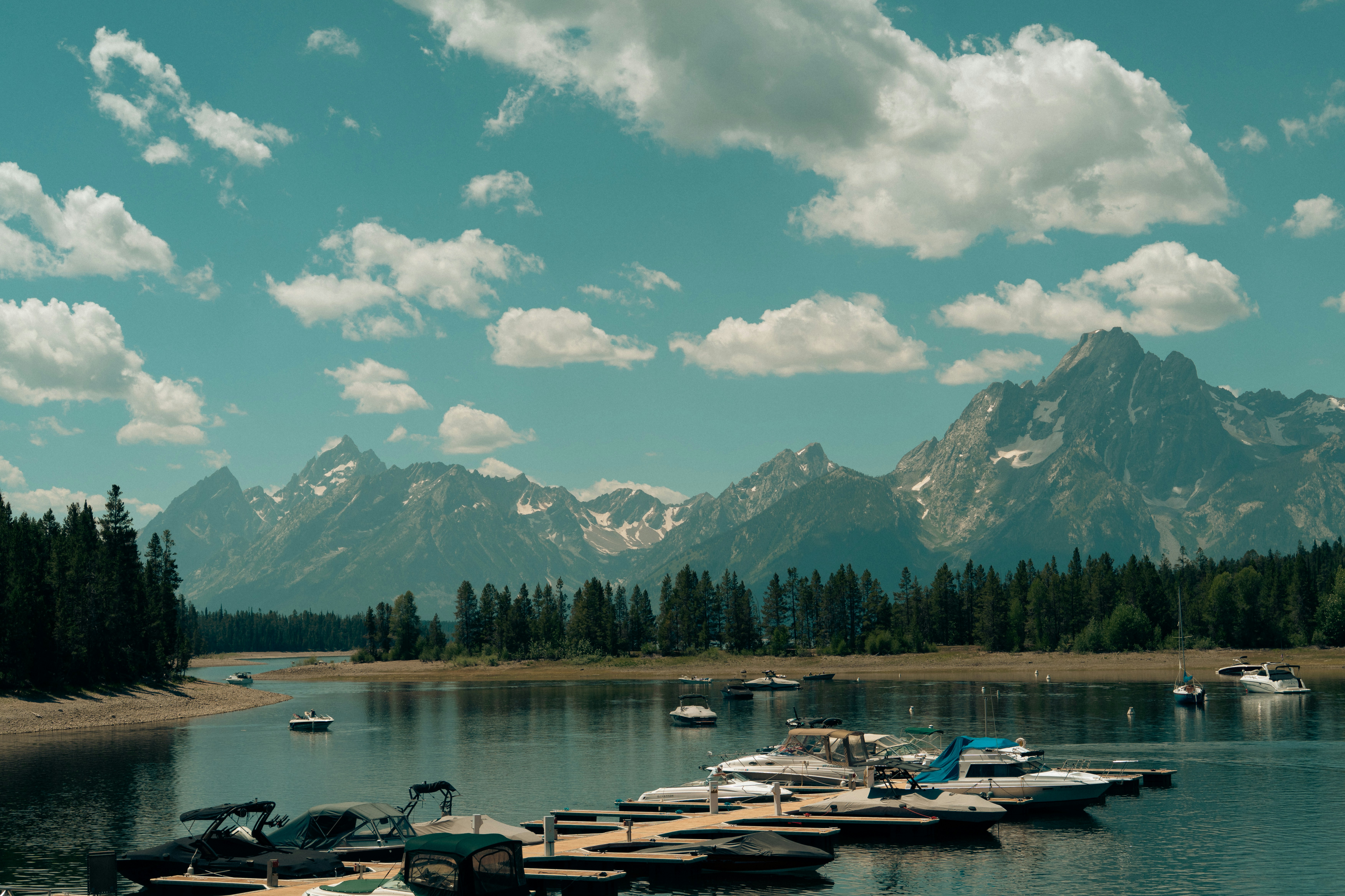 Alpine Reflections: Boats at the Quiet Lake Under Snowy Peaks