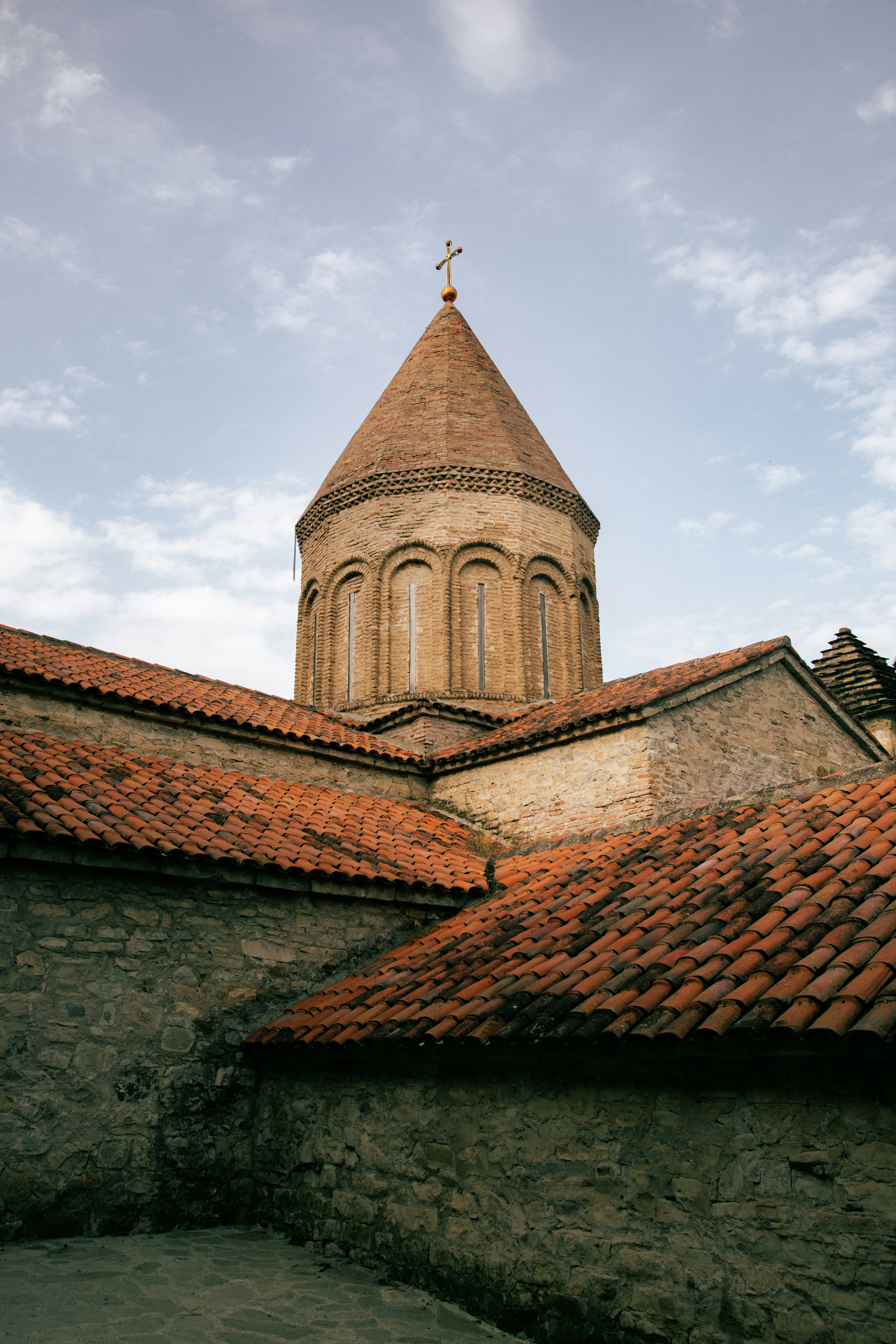 Cobbled Rooflines Reaching Toward a Brick Bell Tower