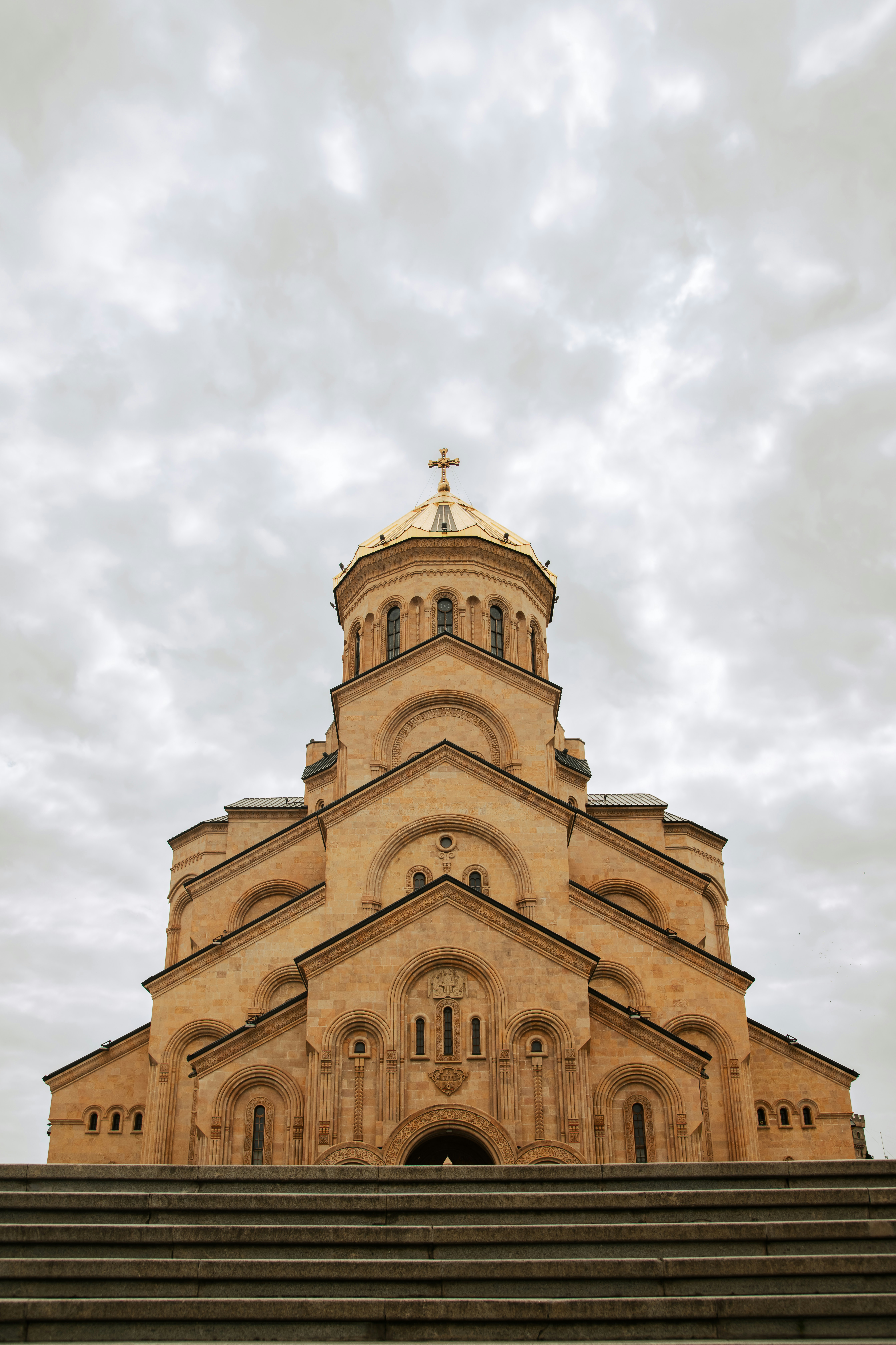 Stone Cathedral Ascending: A stepped facade toward the cloudy sky