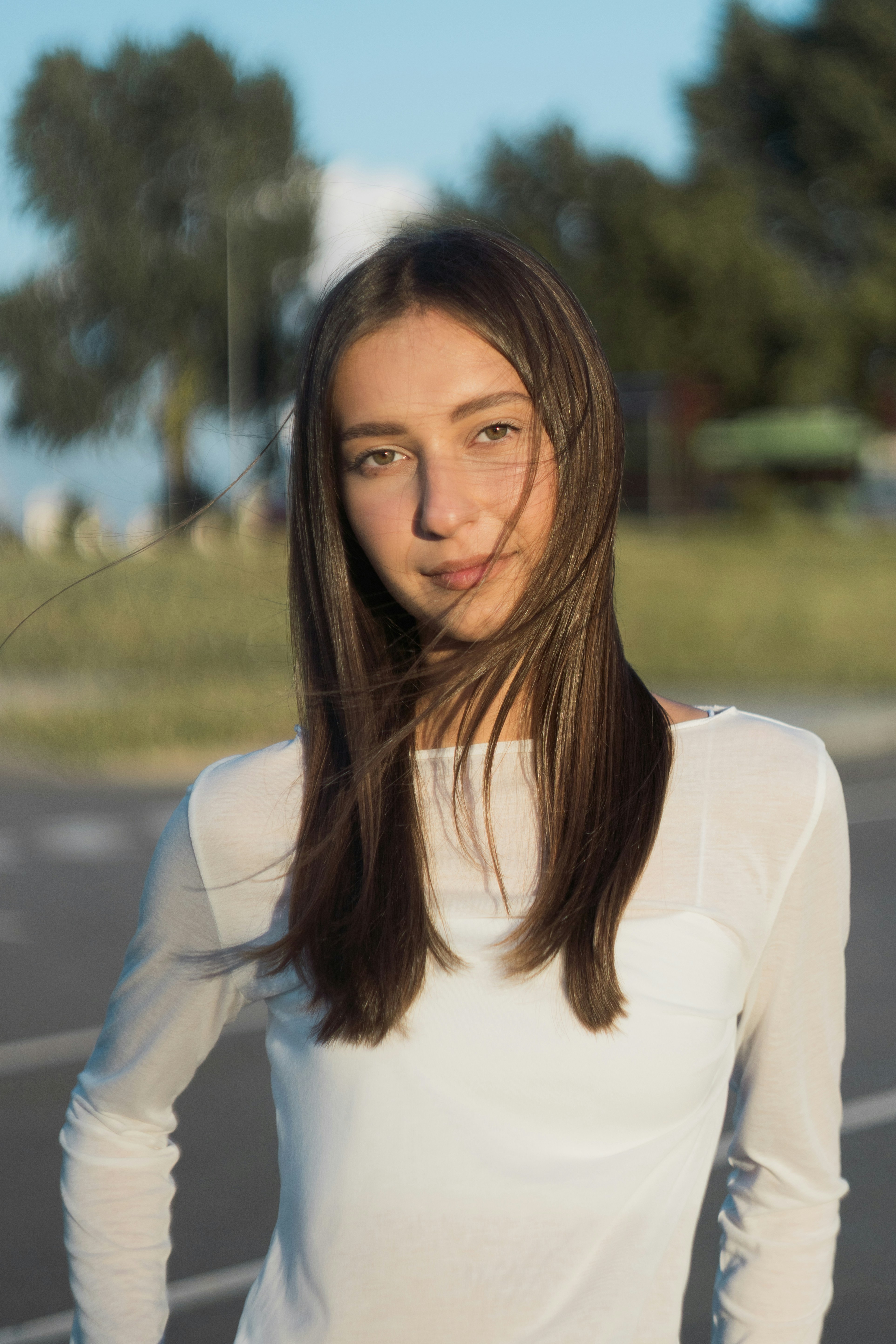 Portrait in soft afternoon light: a poised gaze against a sunlit backdrop
