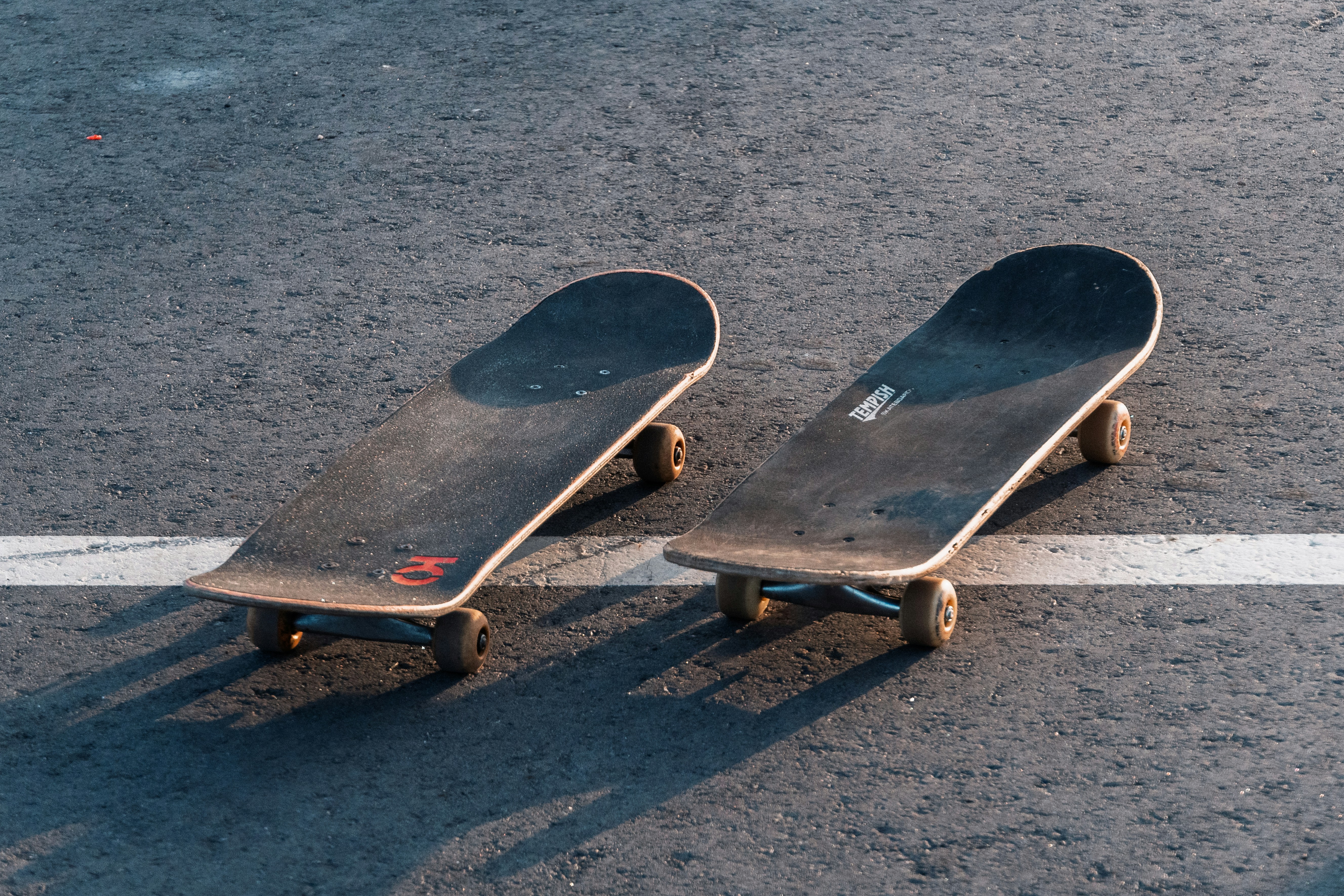 Twin Skateboards in Sunlit Asphalt: A Quiet Moment of Balance