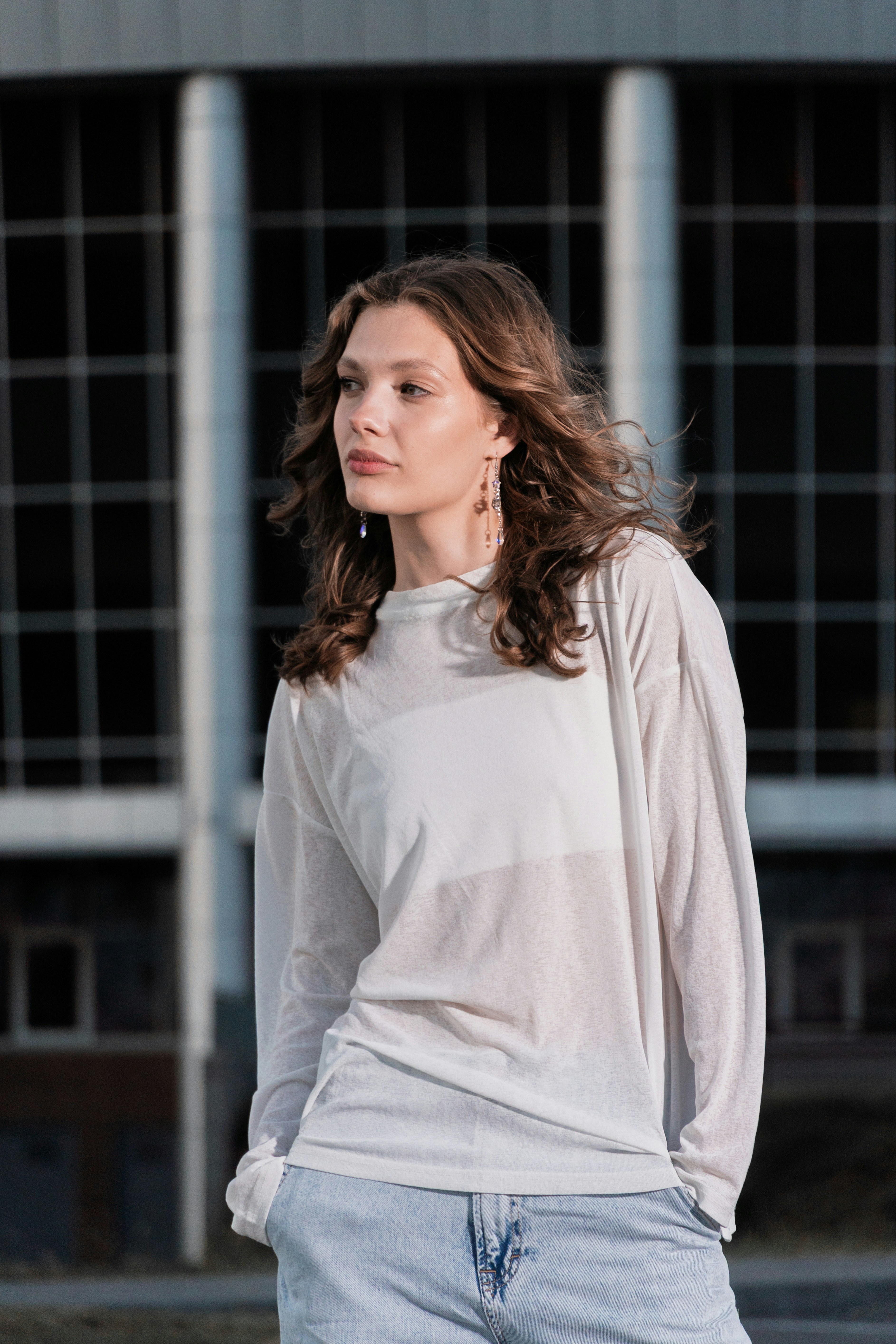 Soft Confidence: Portrait of a Woman Against a Modern Facade