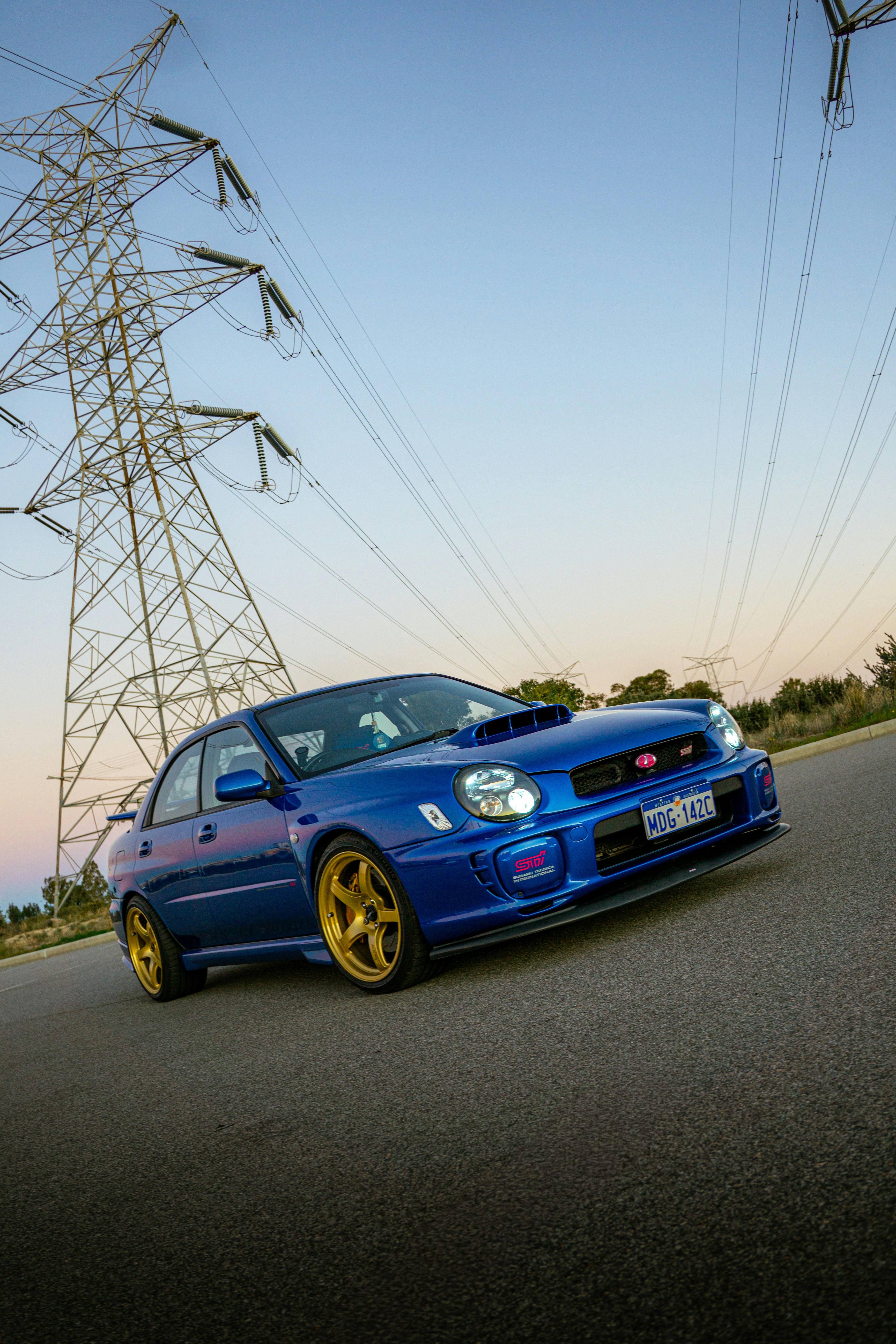 Blue Subaru under Anodized Power Lines