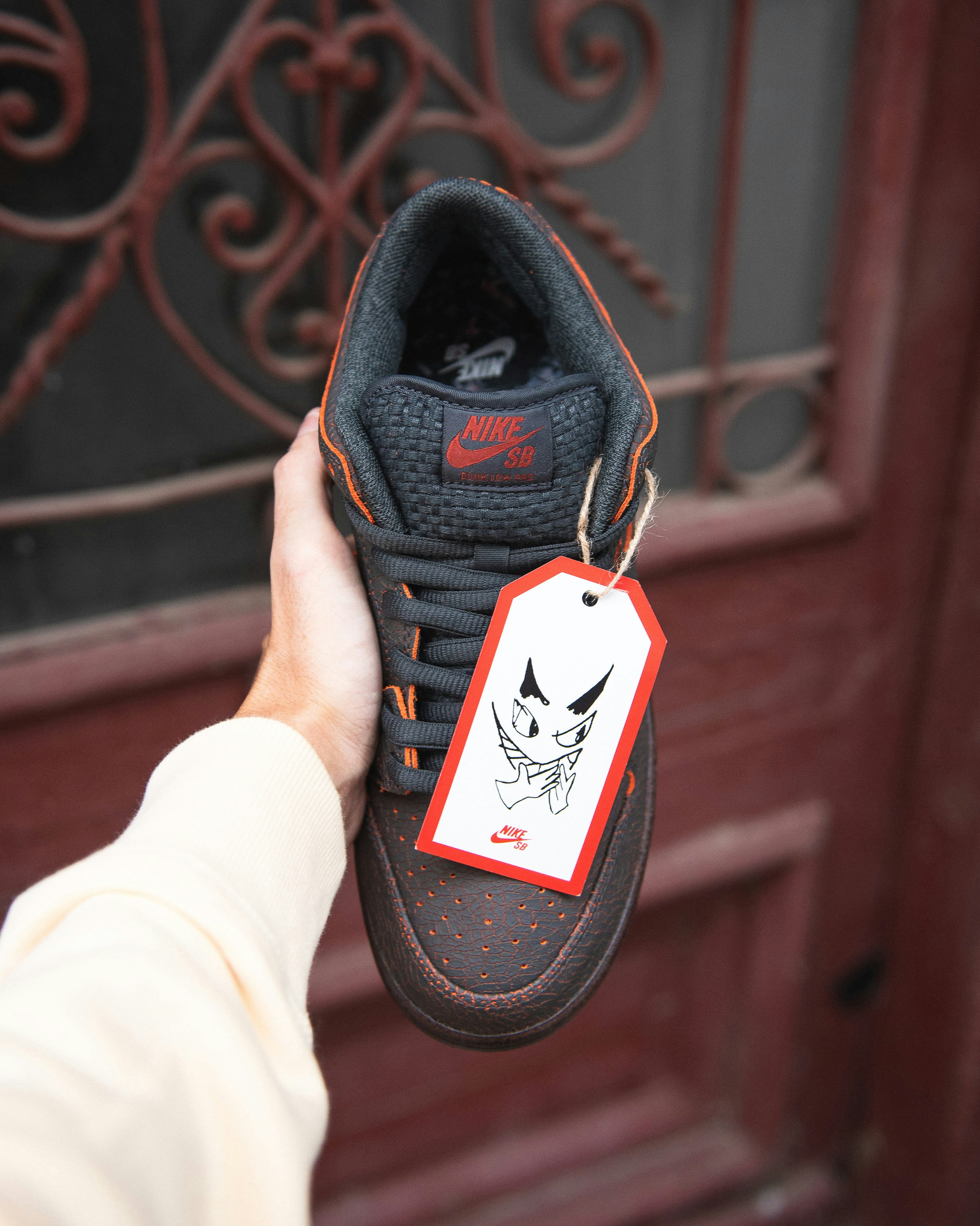 Tagged Sneaker: A Bold Kick Dangles Before a Wrought Iron Door