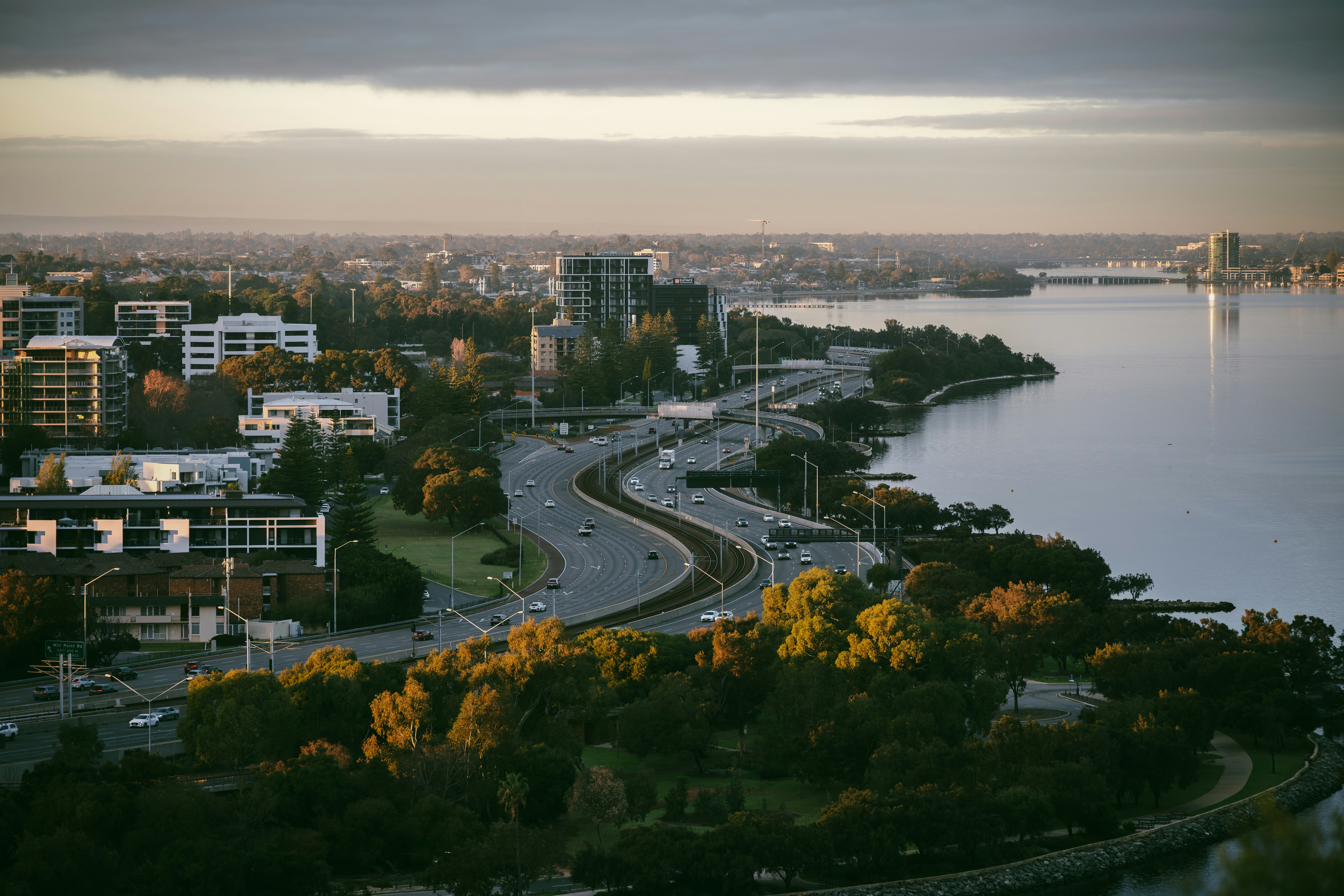 Sunlit Riverbend Overlook: A Panoramic City by the Water