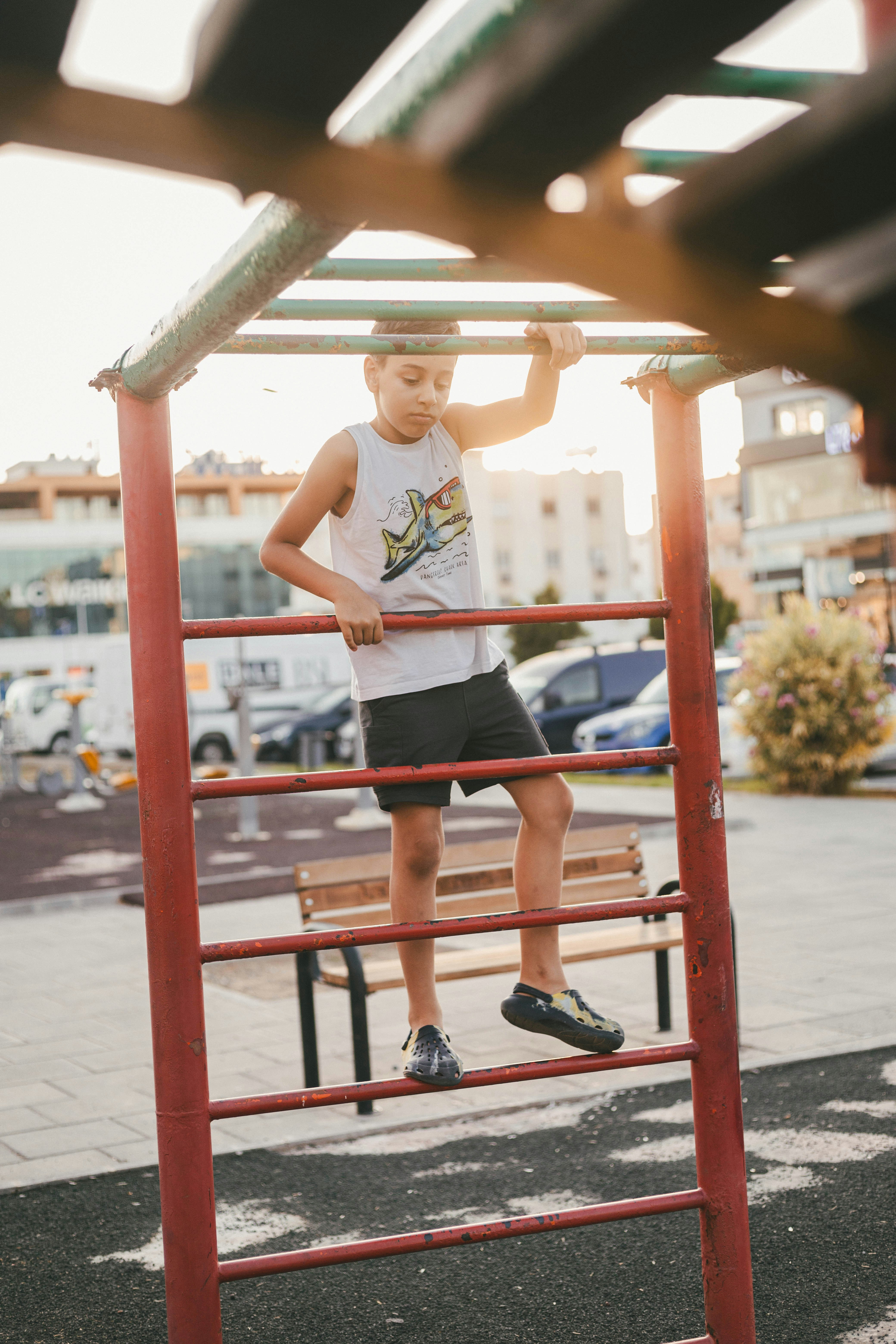 Child on Monkey Bars in Sunset Urban Park