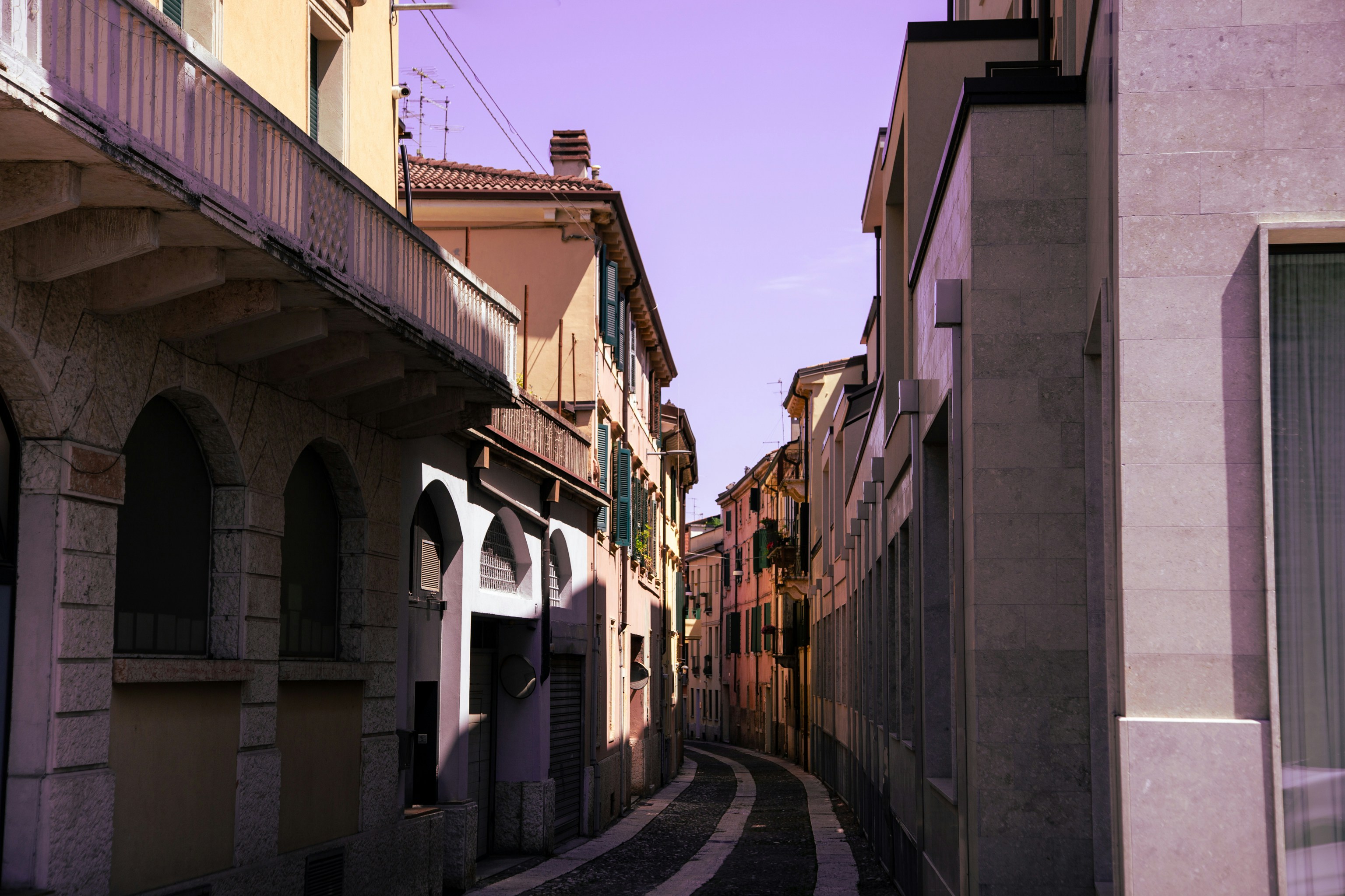 Sunlit Alleyway: A Quiet Corridor of Colorful Facades