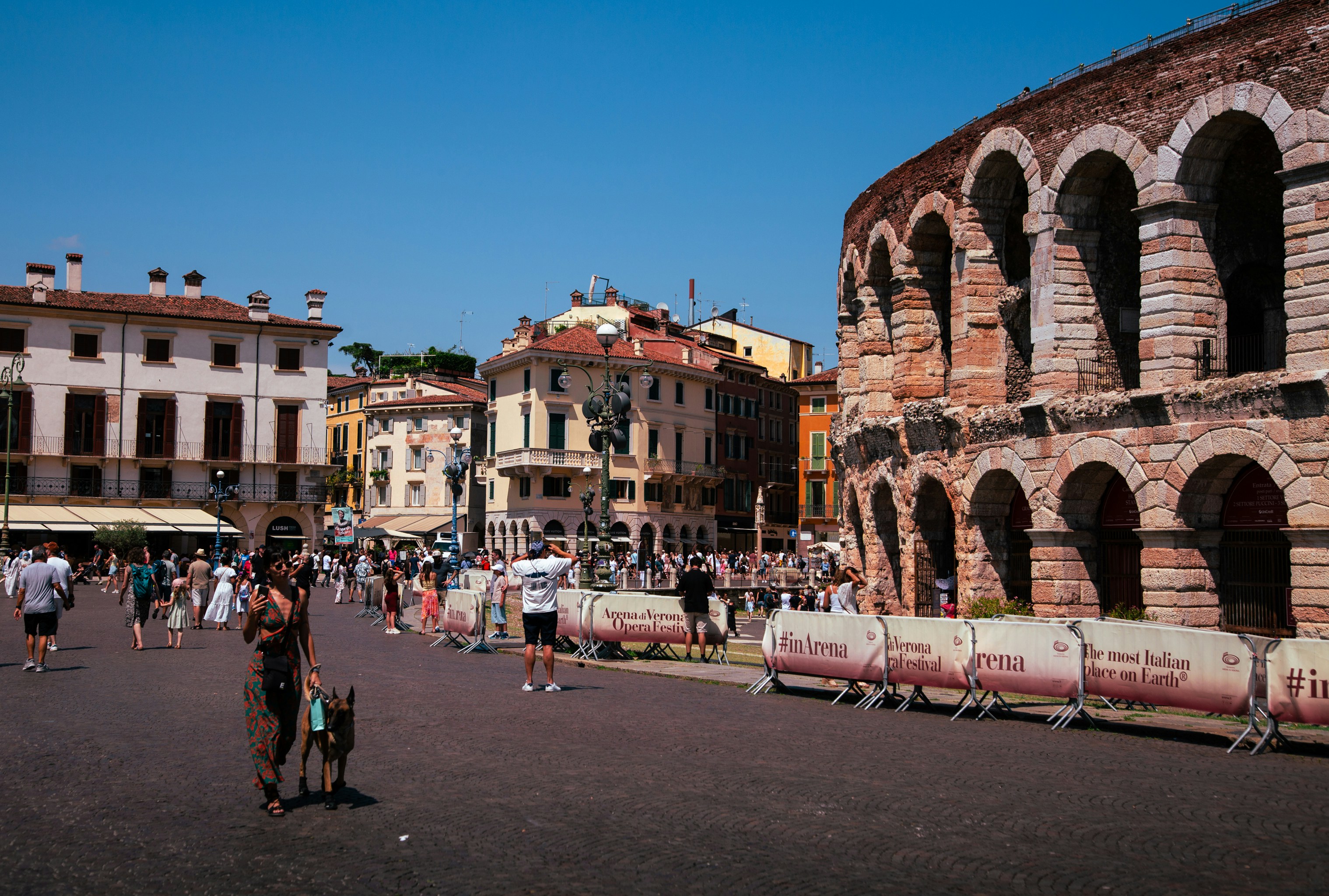 Sunlit Piazza at the Arena: People and Historic Arches