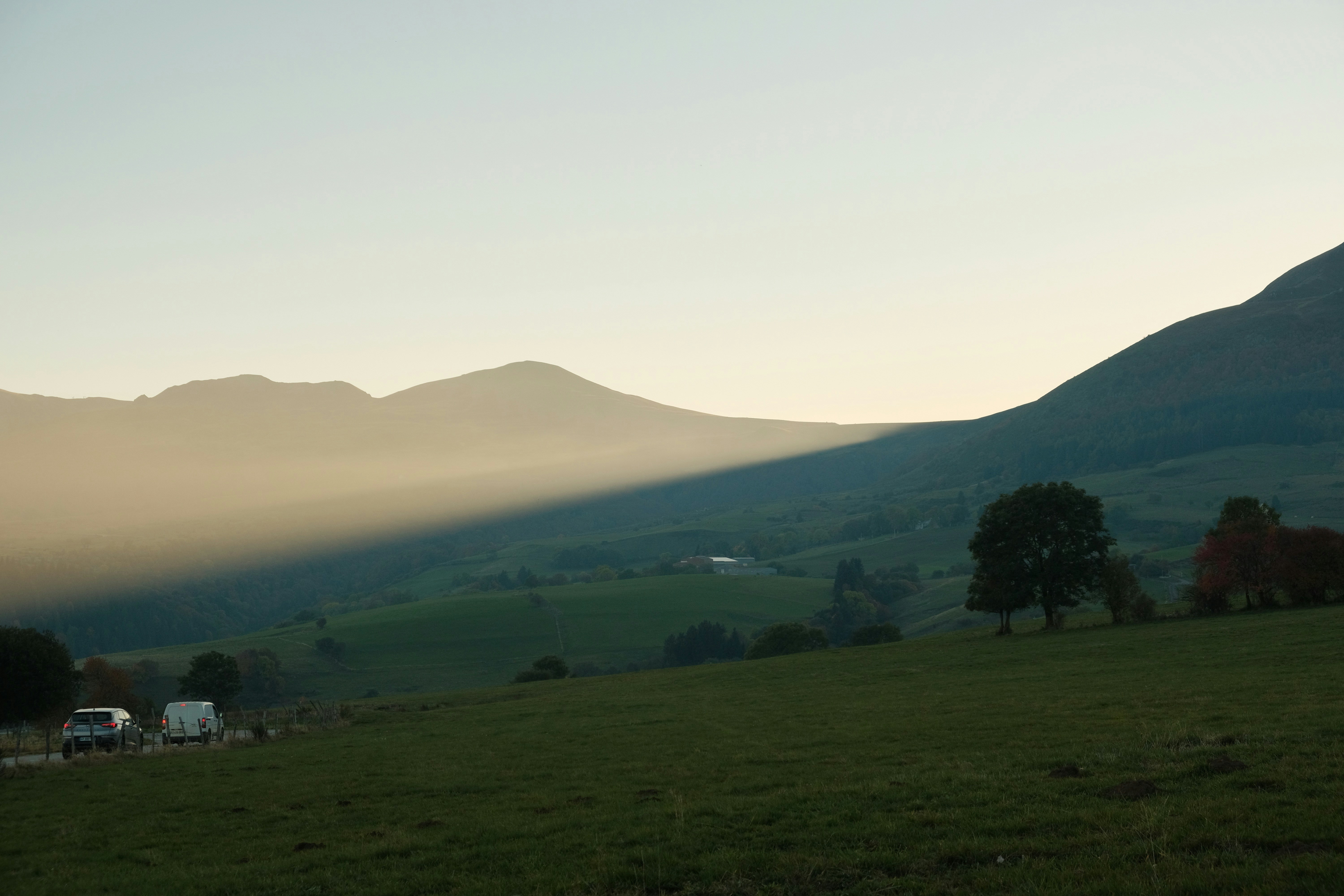 Morning Mist Over Rolling Pastures and Distant Peaks