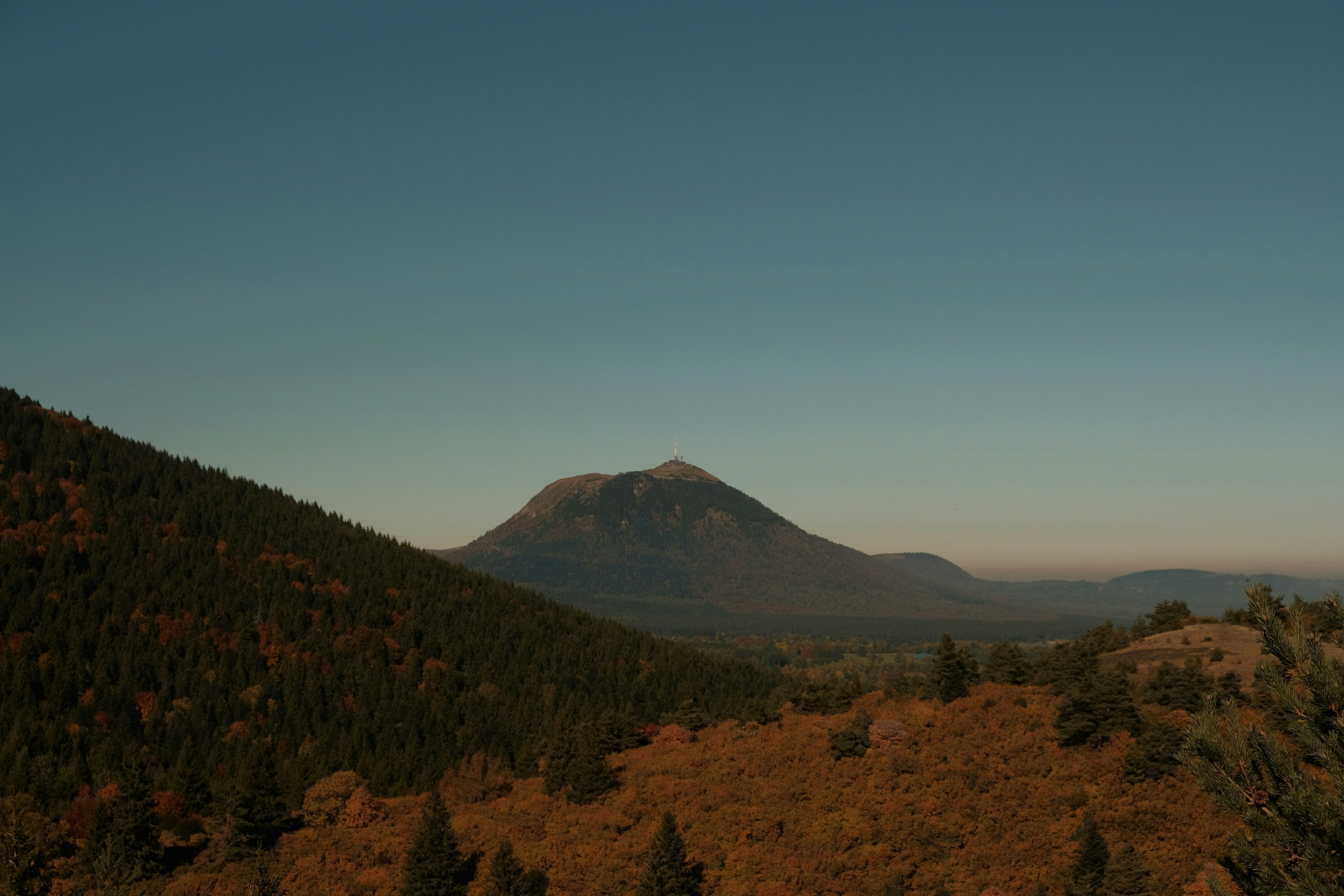 Silent Summit: A Lone Peak Over Autumn Pines