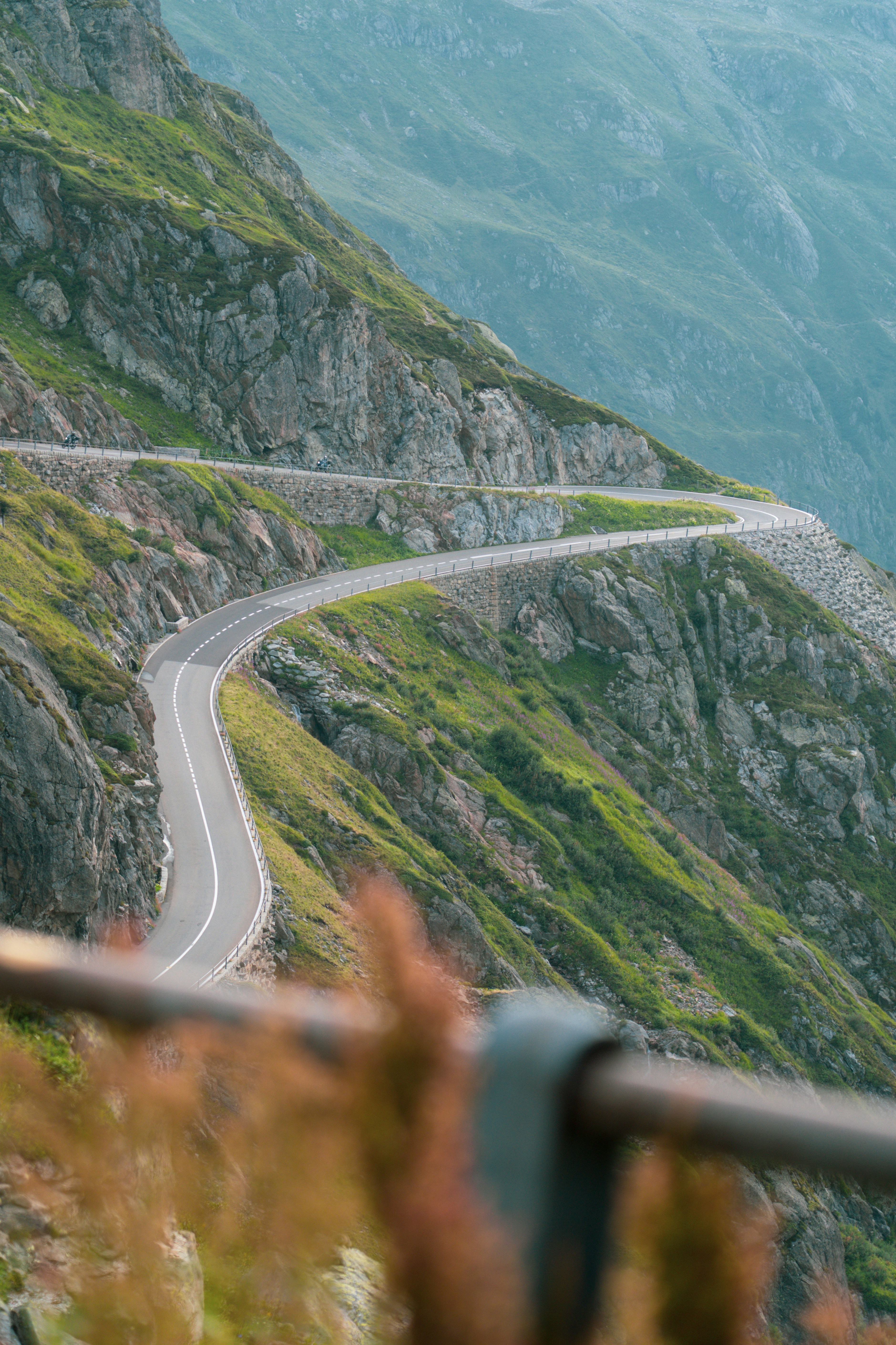 Winding Crest: A Serpentine Road Claws its Way Along Alpine Cliffs