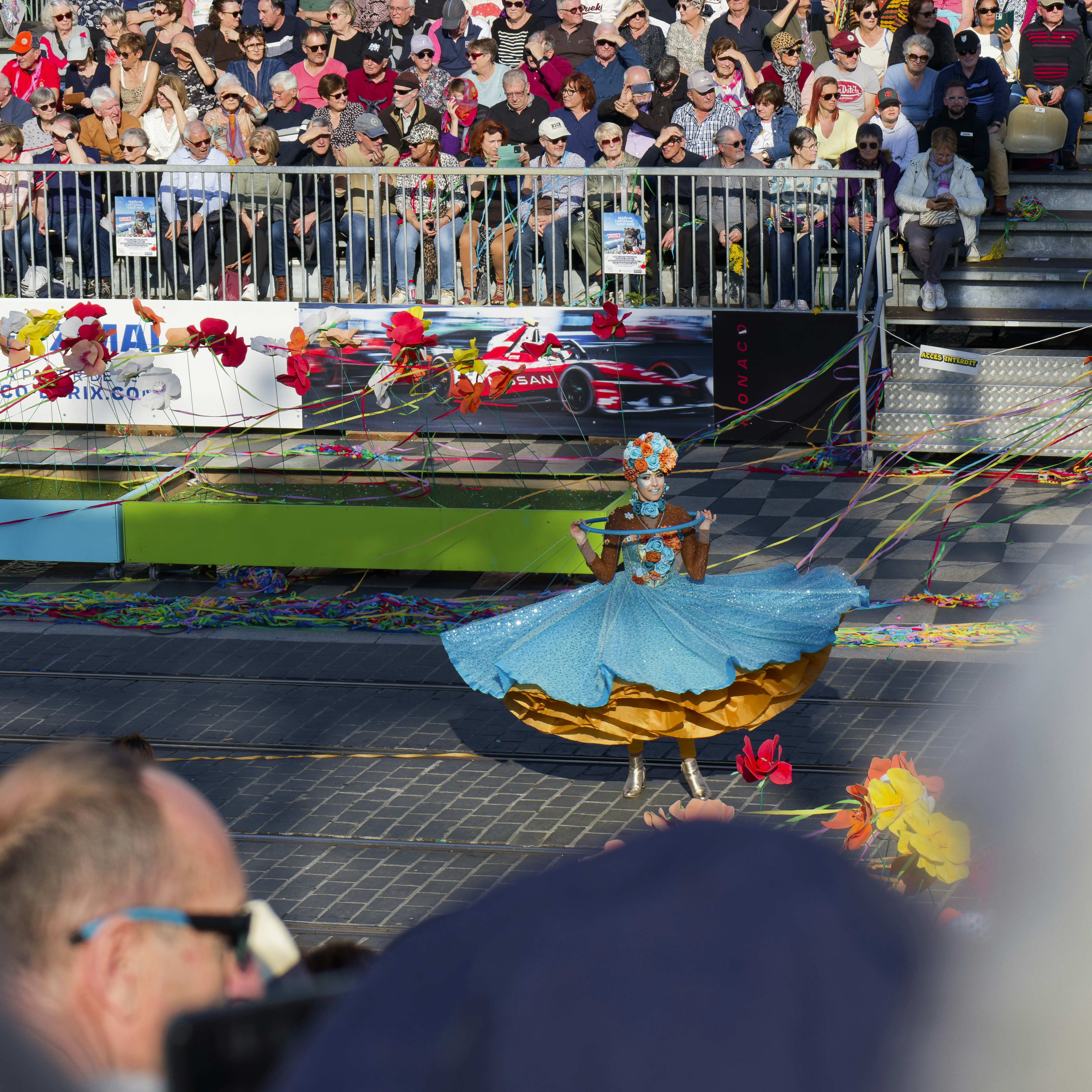 Circle of Color: Dancer in Blue Amid Festive Confetti on a Grandstand Stage