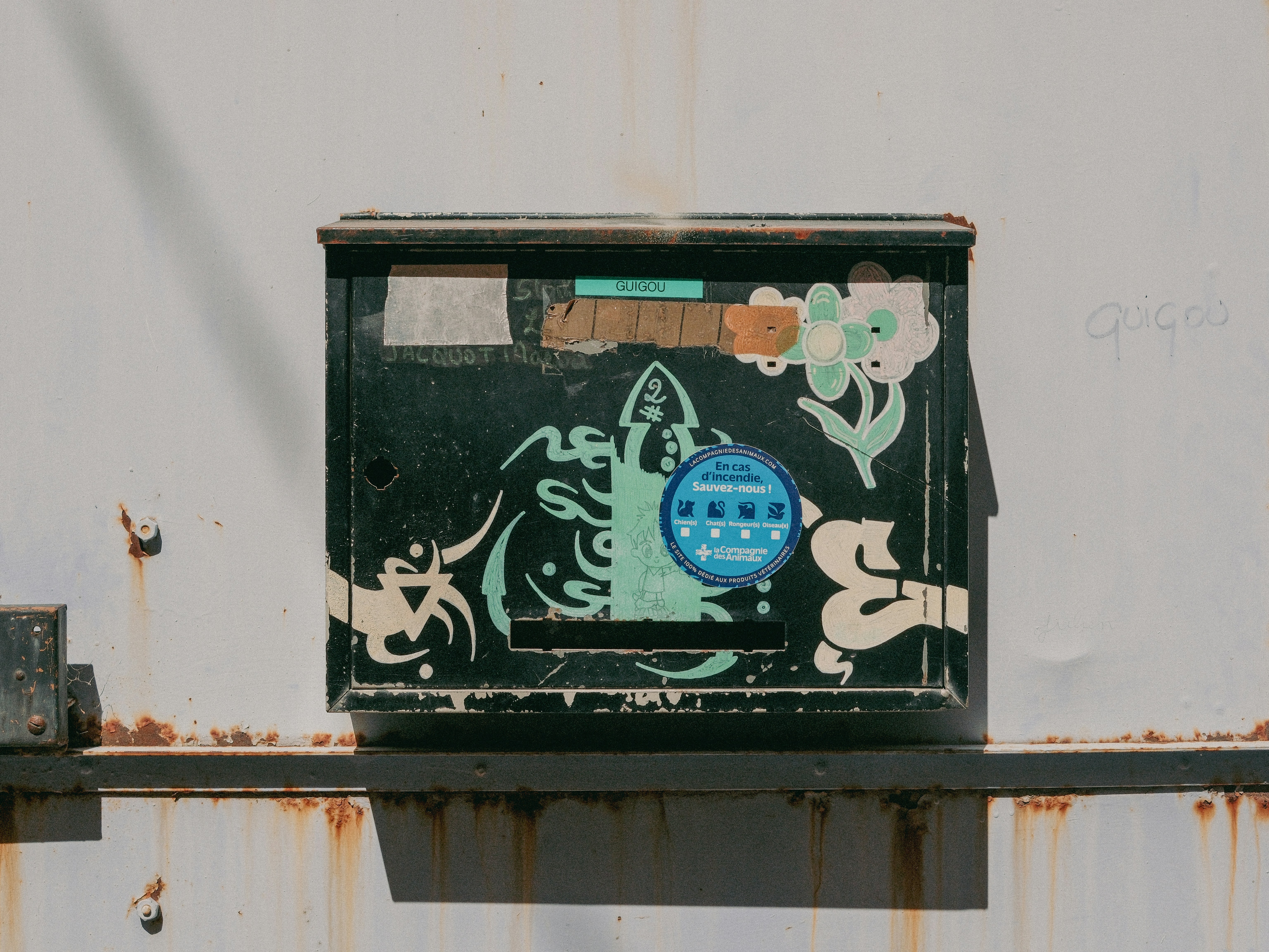 Masked Mailbox in a Rust-streaked Wall